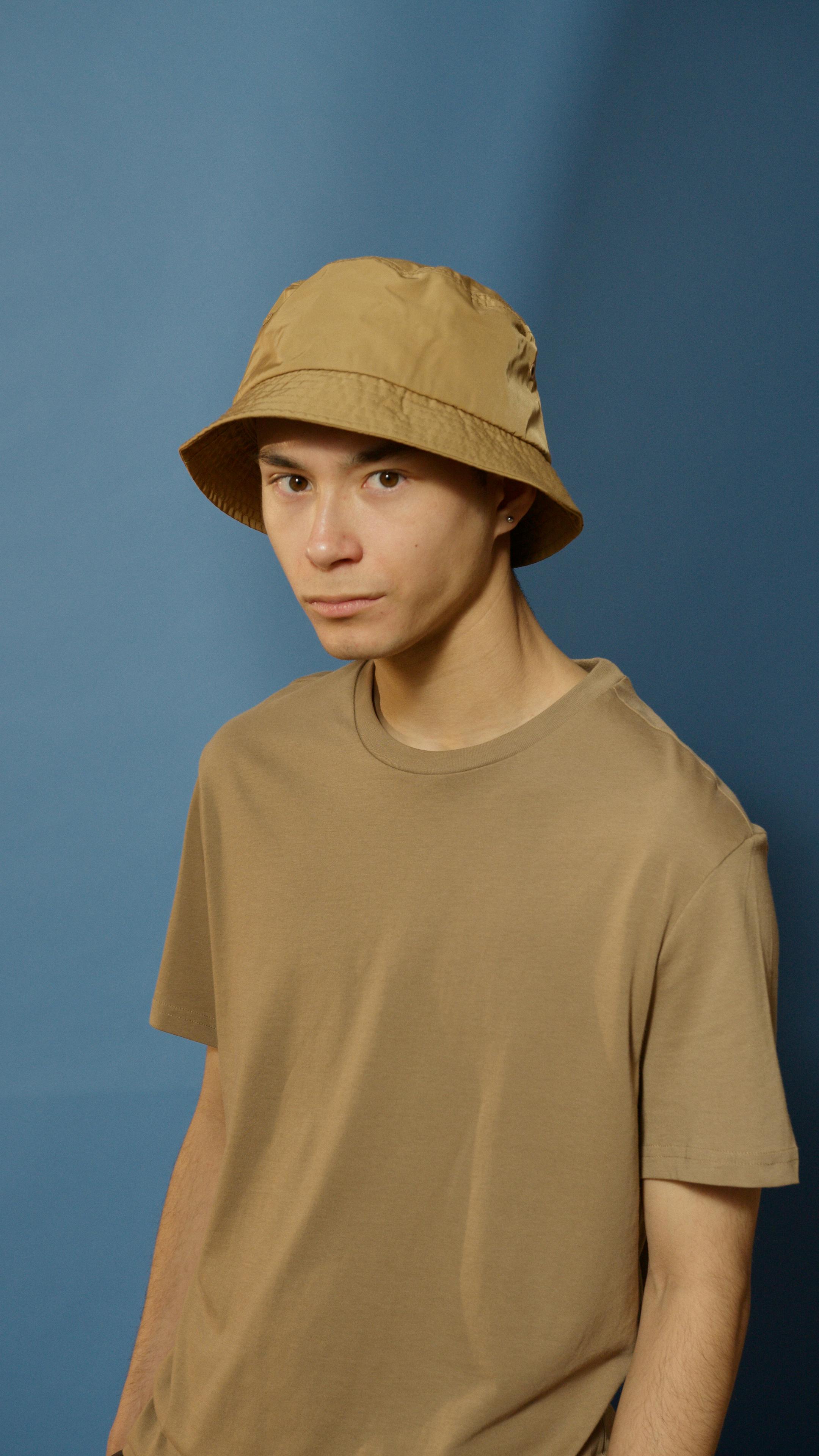 Portrait of Sitting Smiling Man with Bucket Hat · Free Stock Photo