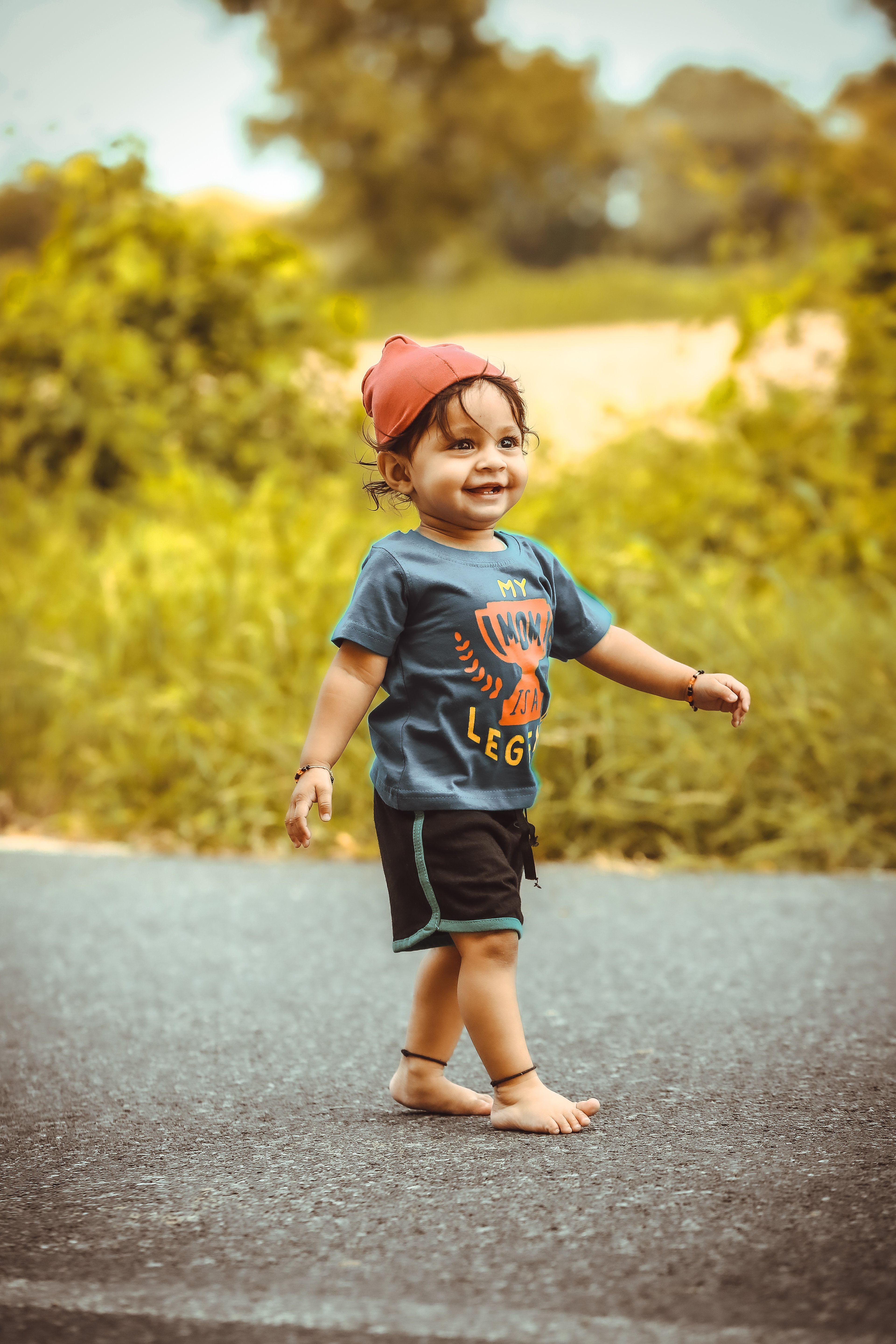 Adorable Kid Smiling While Walking on Asphalt Pavement · Free Stock Photo