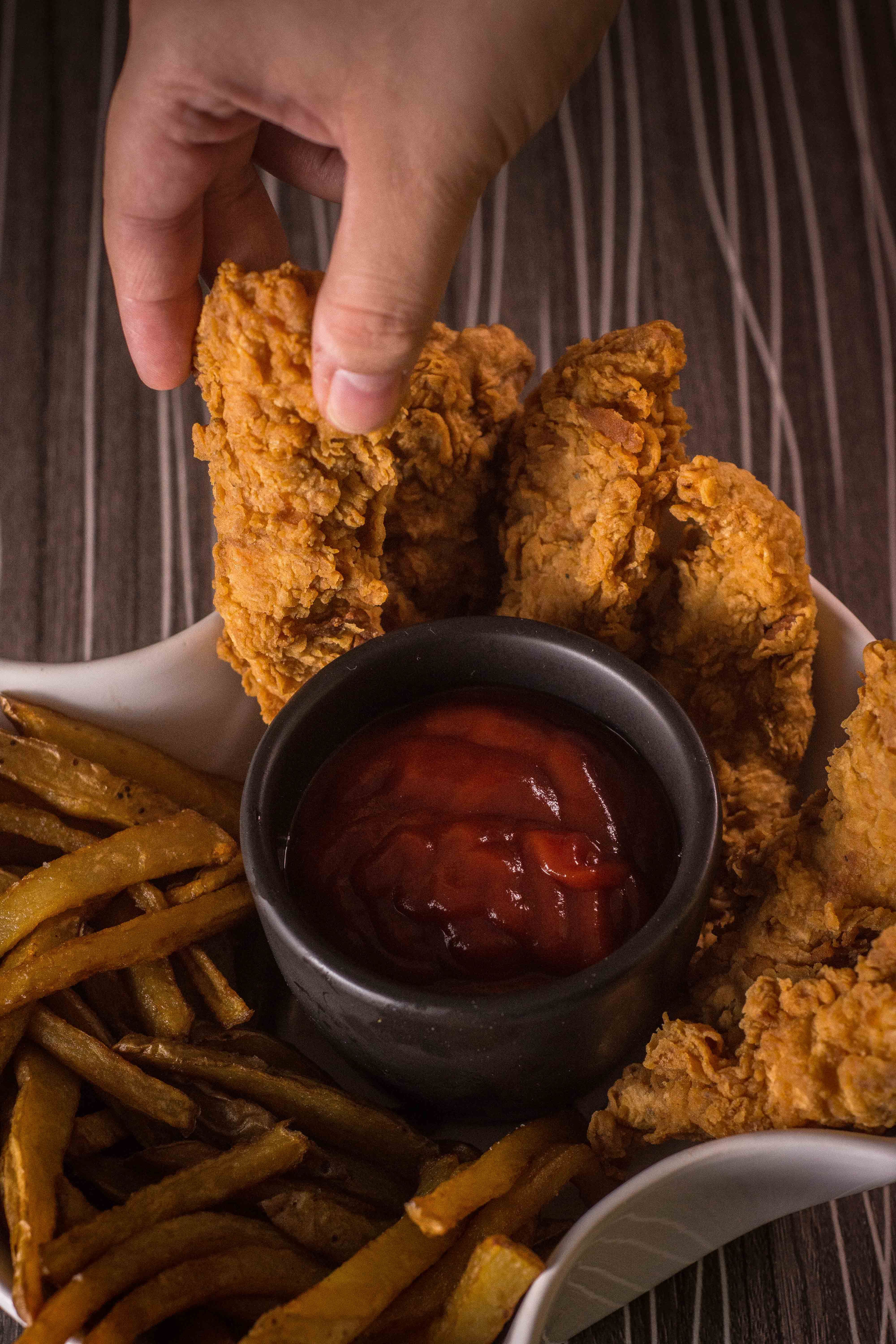 Person Putting Ketchup on Fries · Free Stock Photo