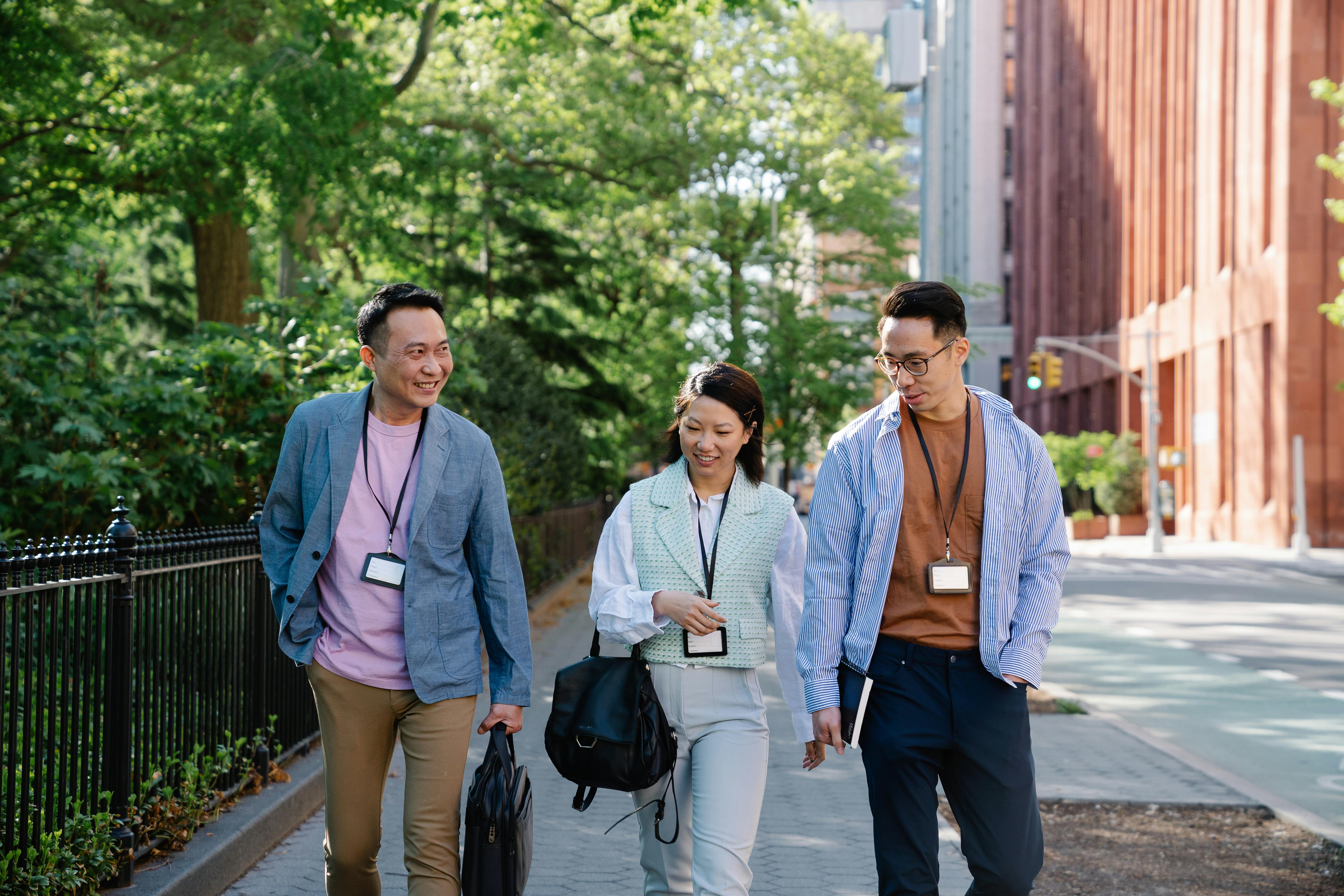 Cheerful People Walking on Sidewalk and Talking · Free Stock Photo
