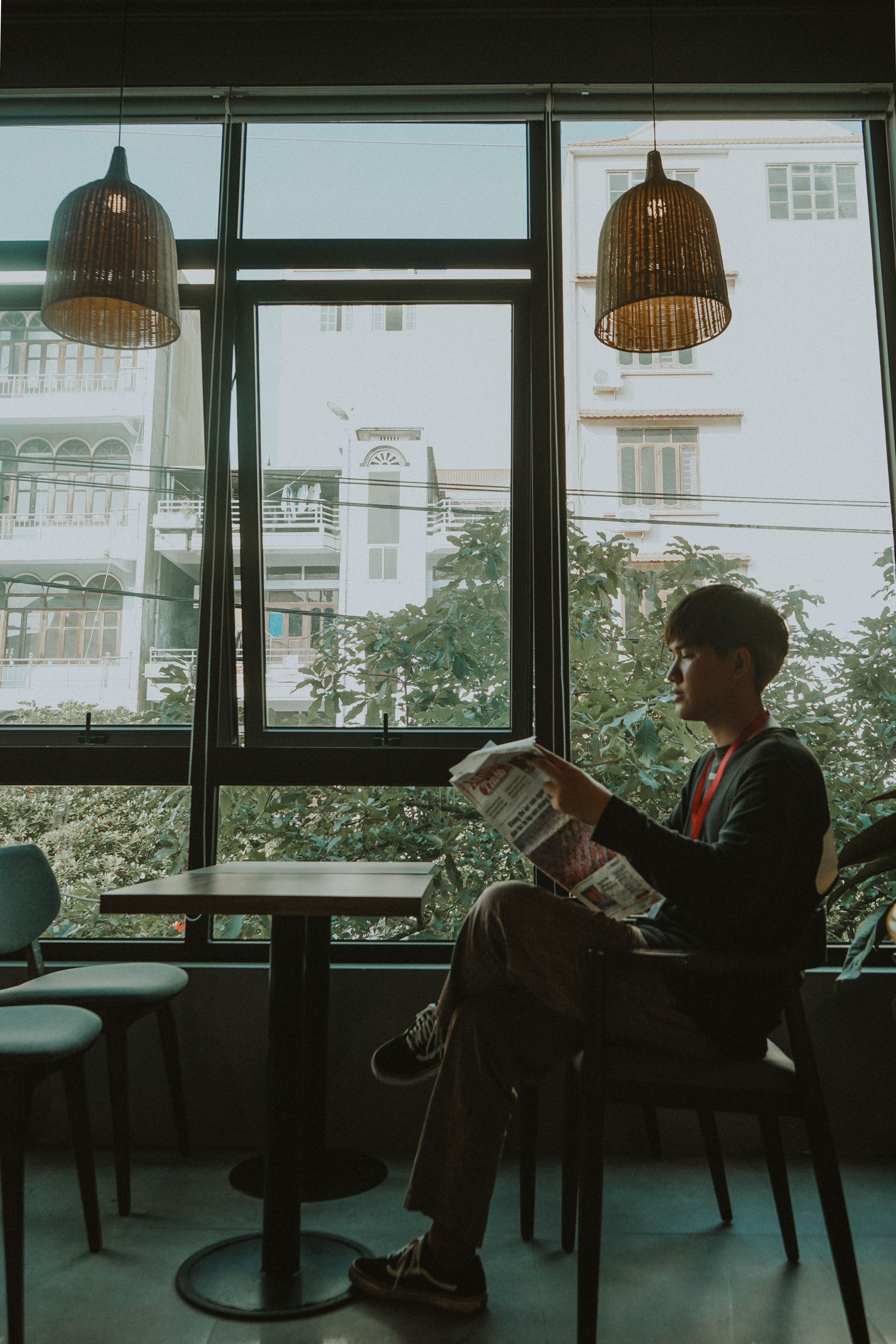 Person Holding Books Beside a Side Table · Free Stock Photo