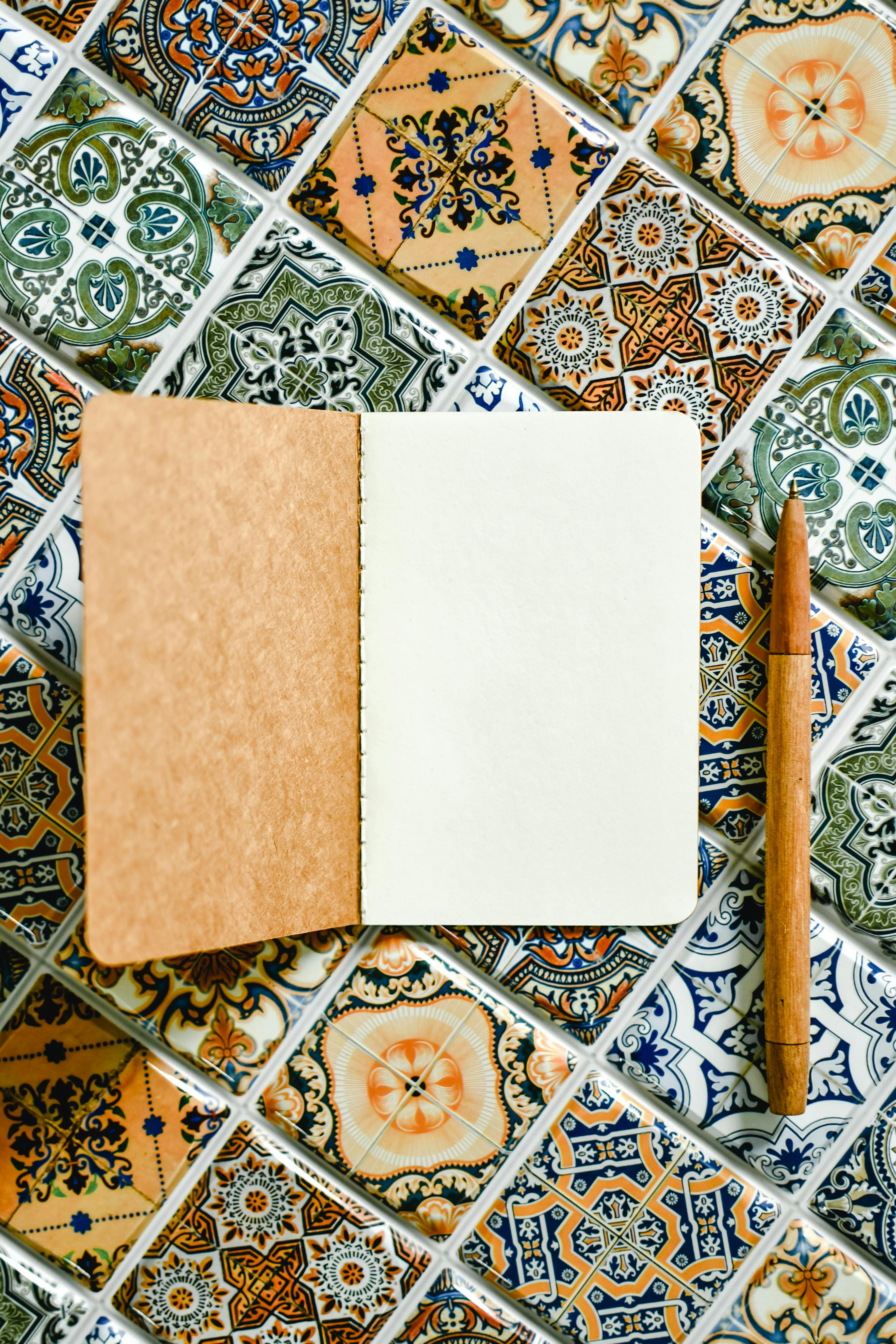 A Notebook and Wooden Pen on Tile Flooring · Free Stock Photo