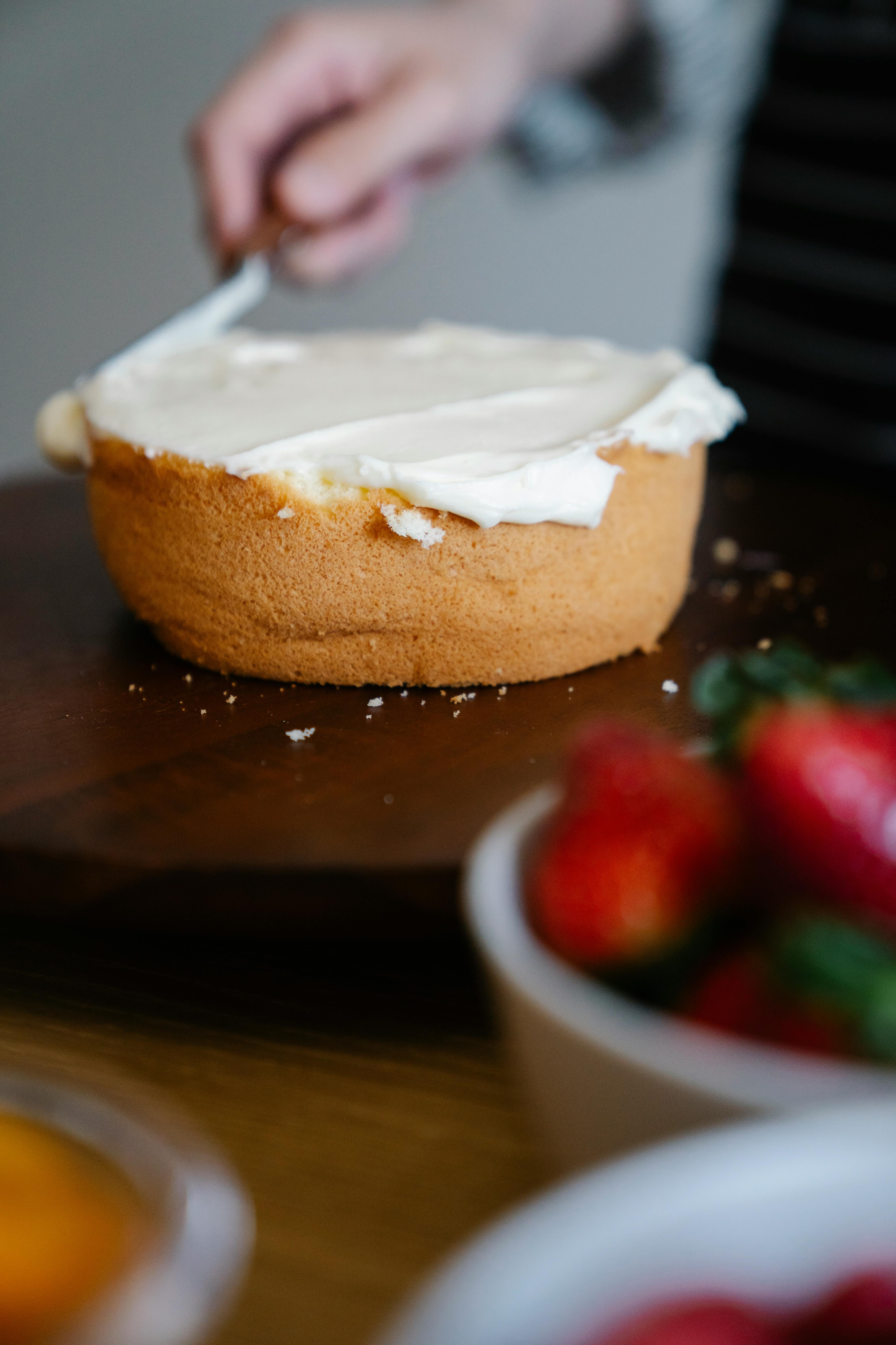 Person Icing a Cake · Free Stock Photo