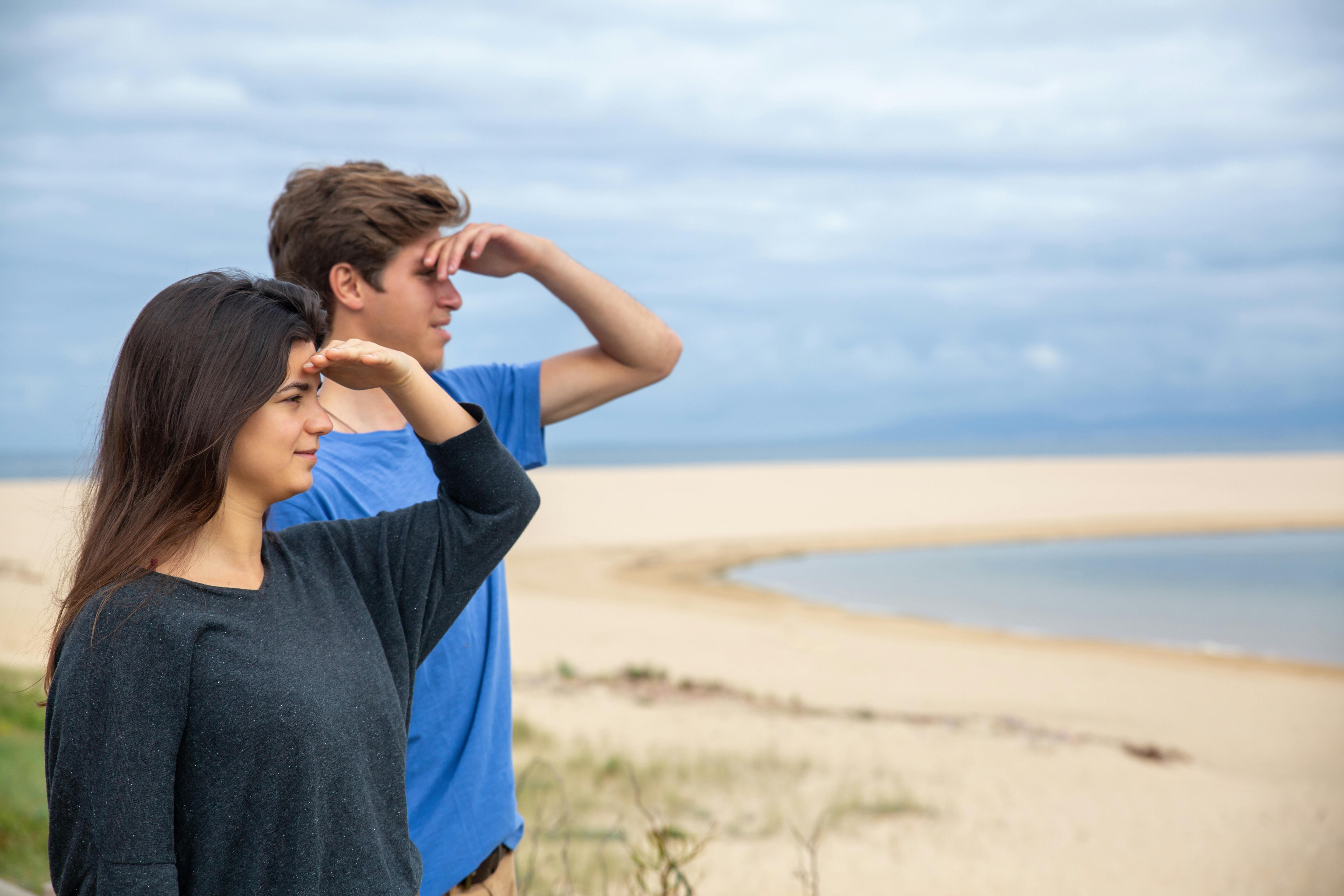 Photo gratuite de ensemble, garçon, jeune fille, plage, regarder au loin