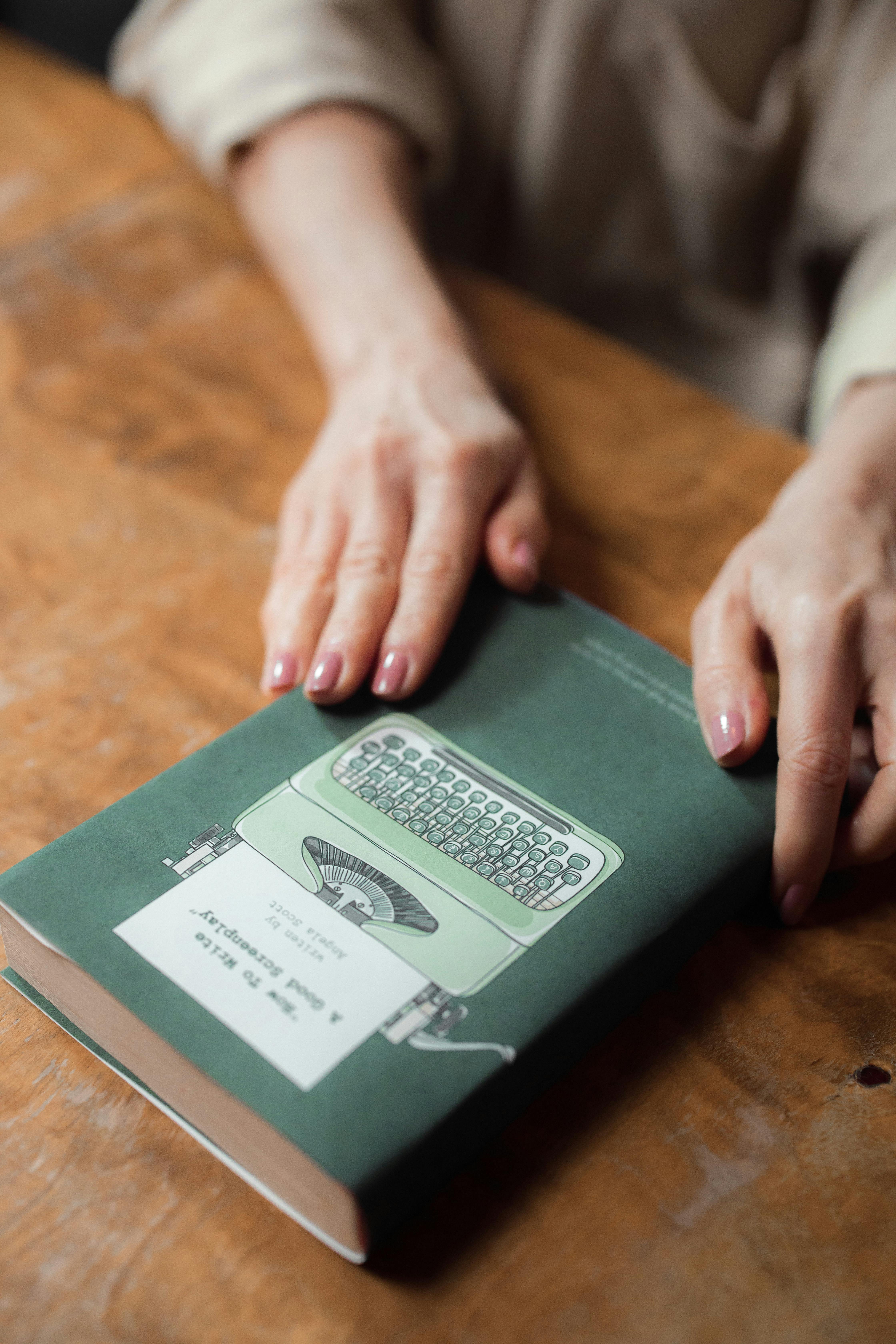 A Person Holding a Green Book · Free Stock Photo