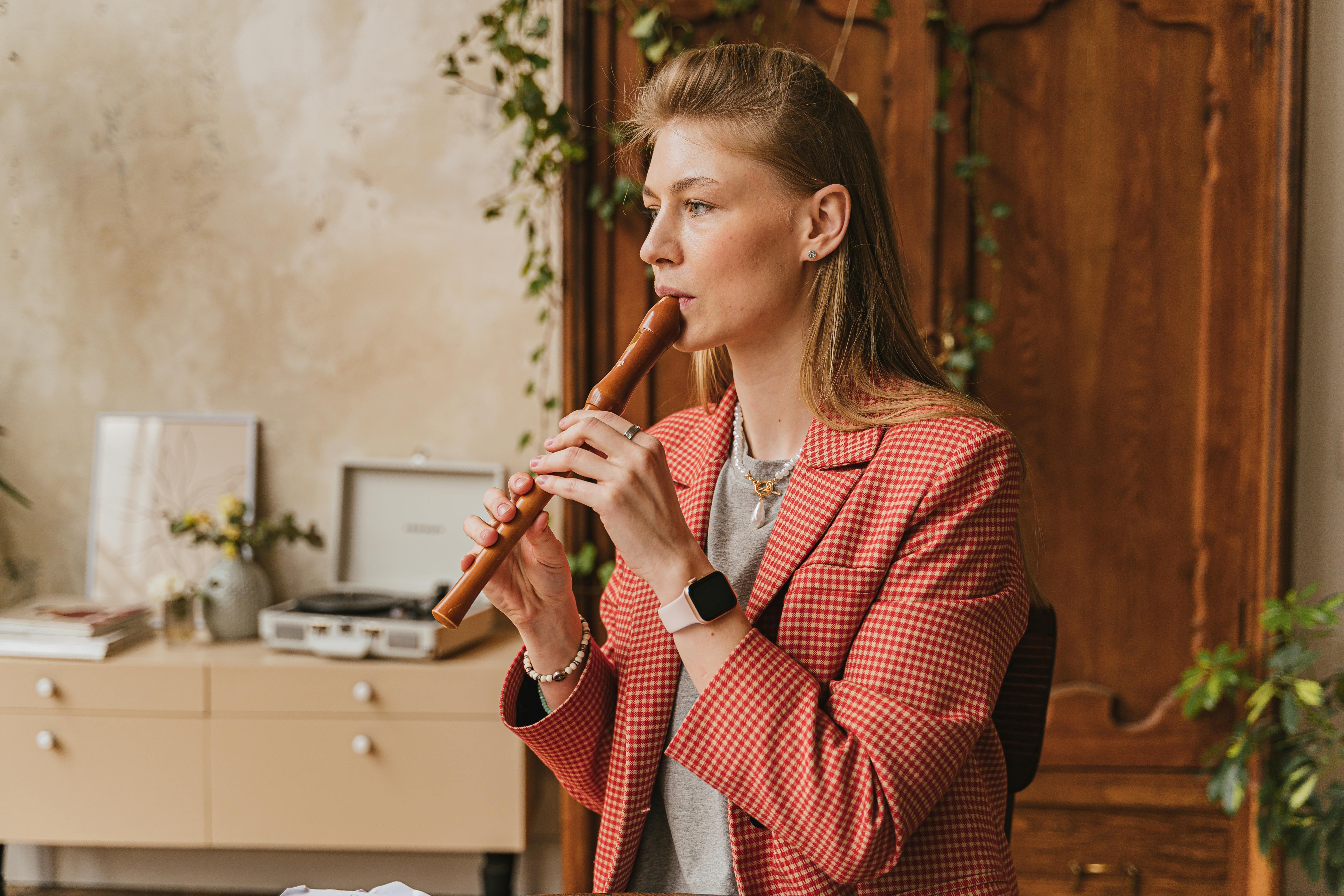 Photo of a Woman Playing a Brown Flute · Free Stock Photo