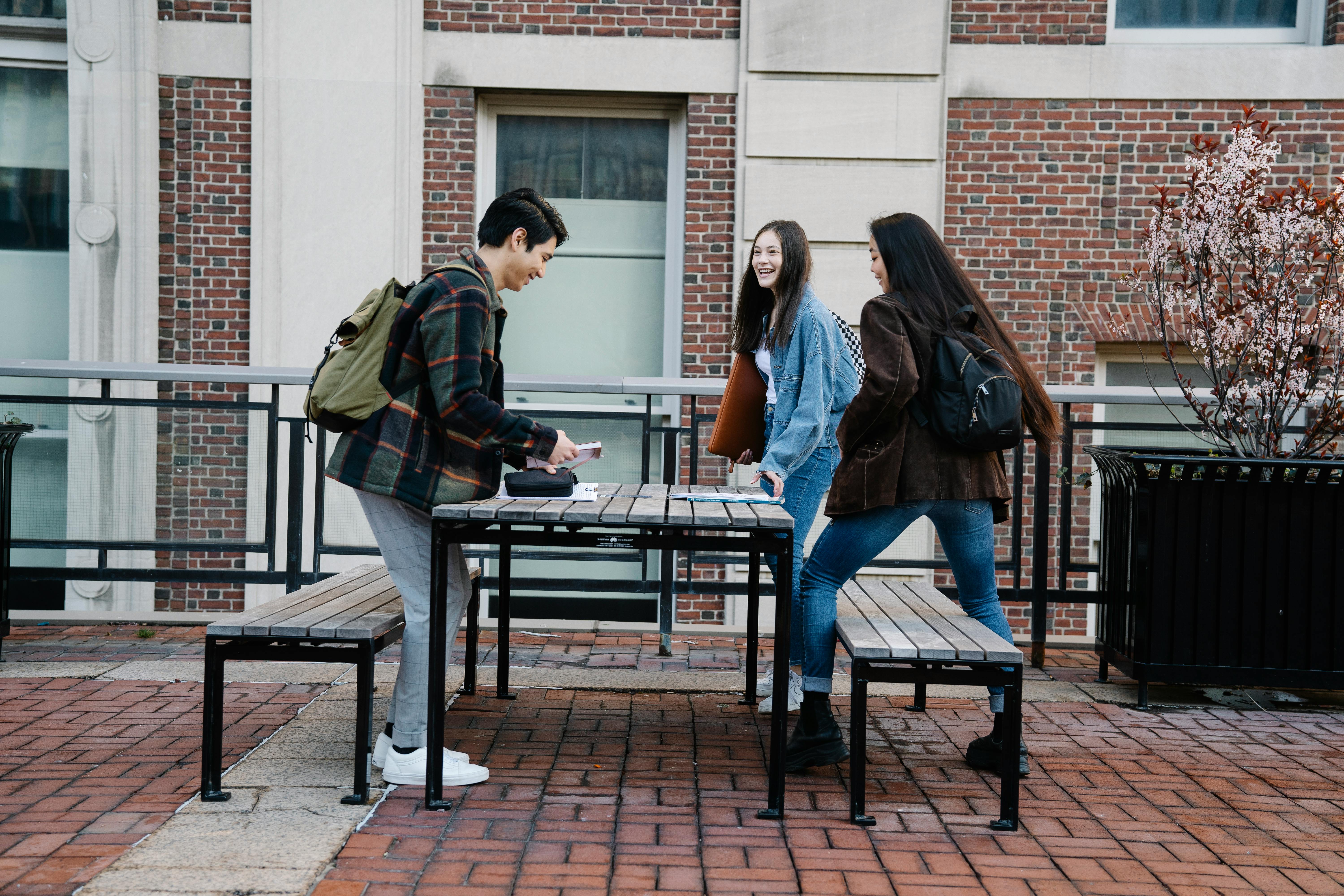 Group of Students Sitting on a Concrete Bench · Free Stock Photo