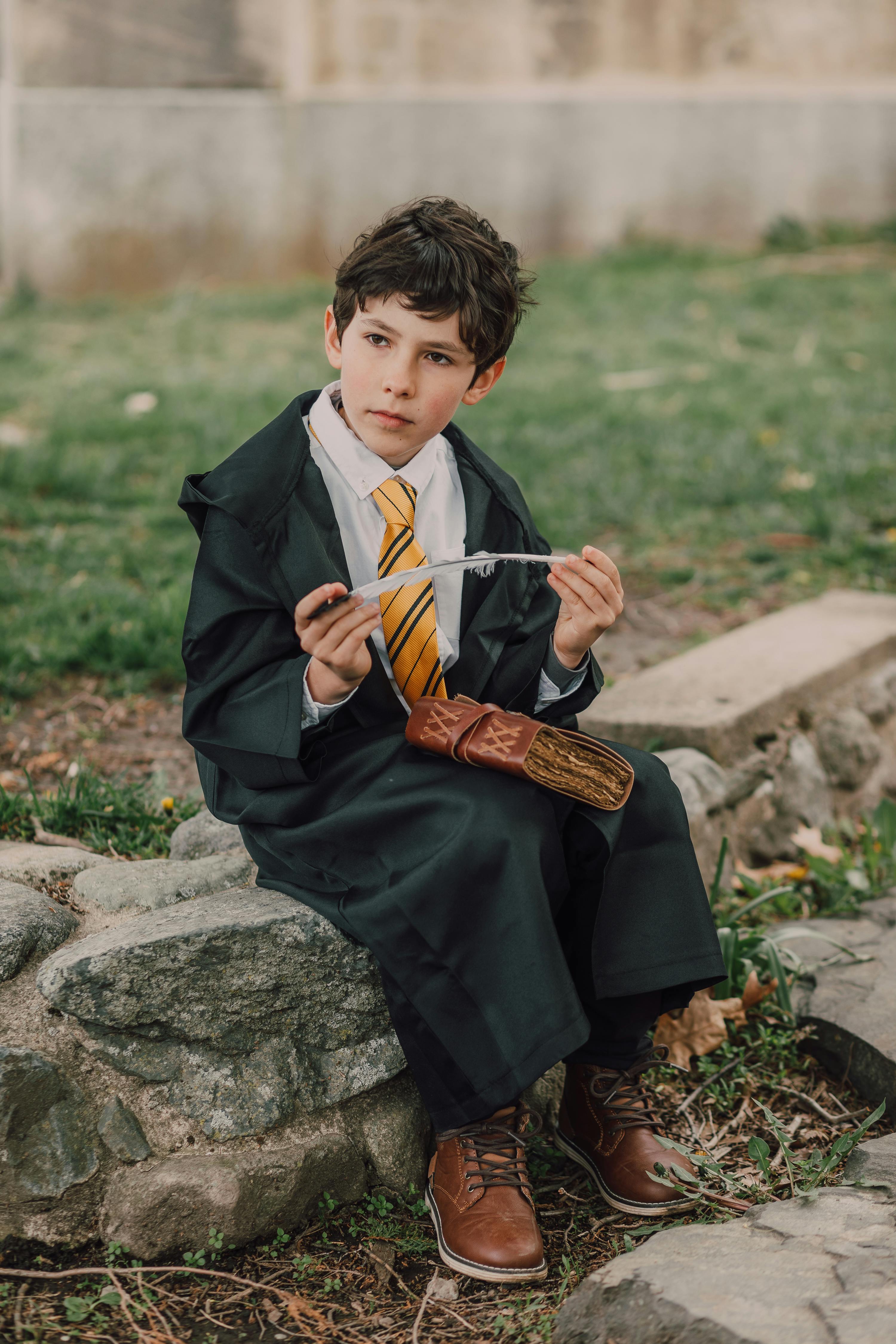 A Kid in Wizard Outfit Holding Wand and Spell Book while Looking Afar ...
