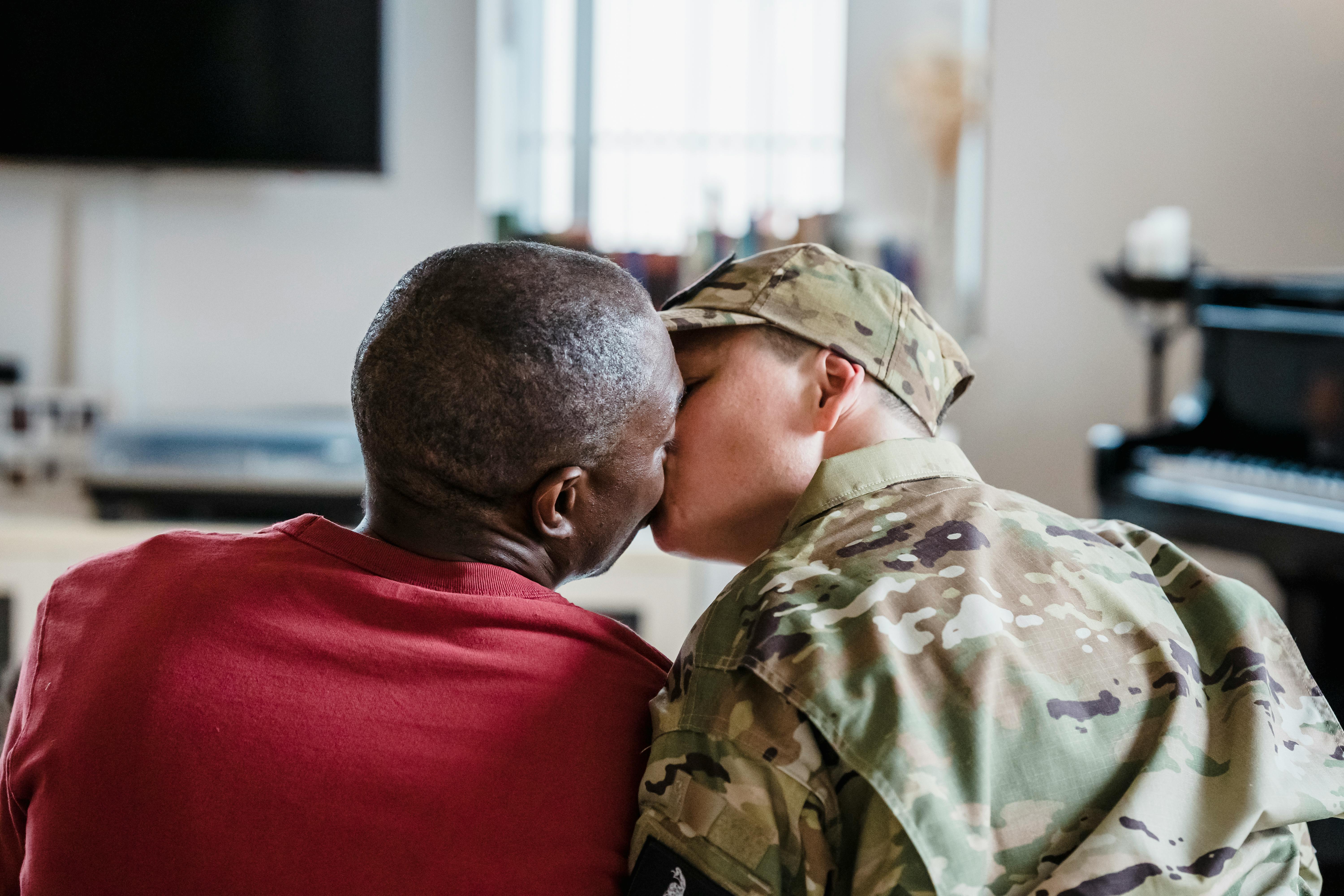 Man Kissing Military Woman on Cheek · Free Stock Photo