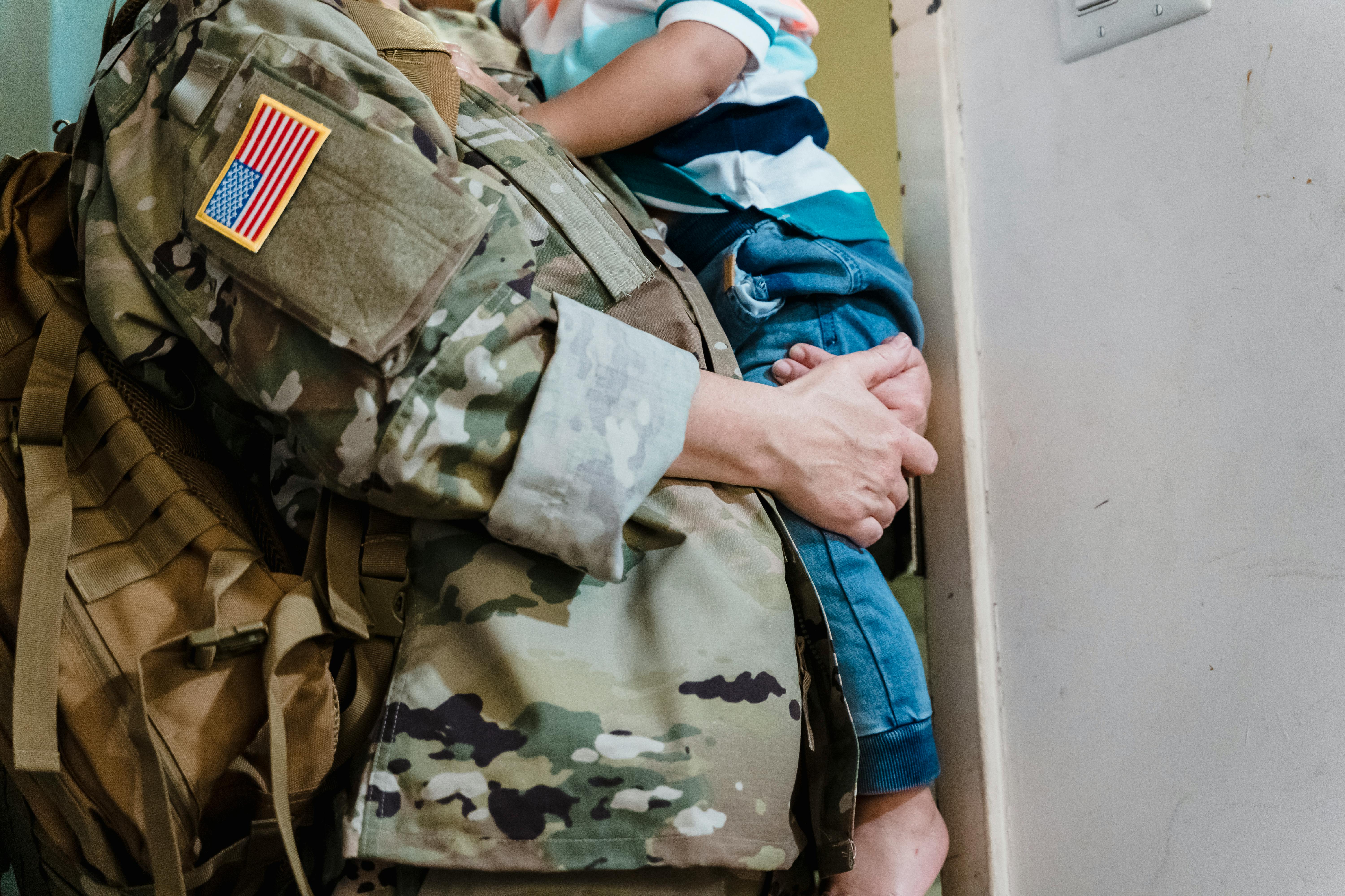 Soldier in a Uniform Holding a Child · Free Stock Photo
