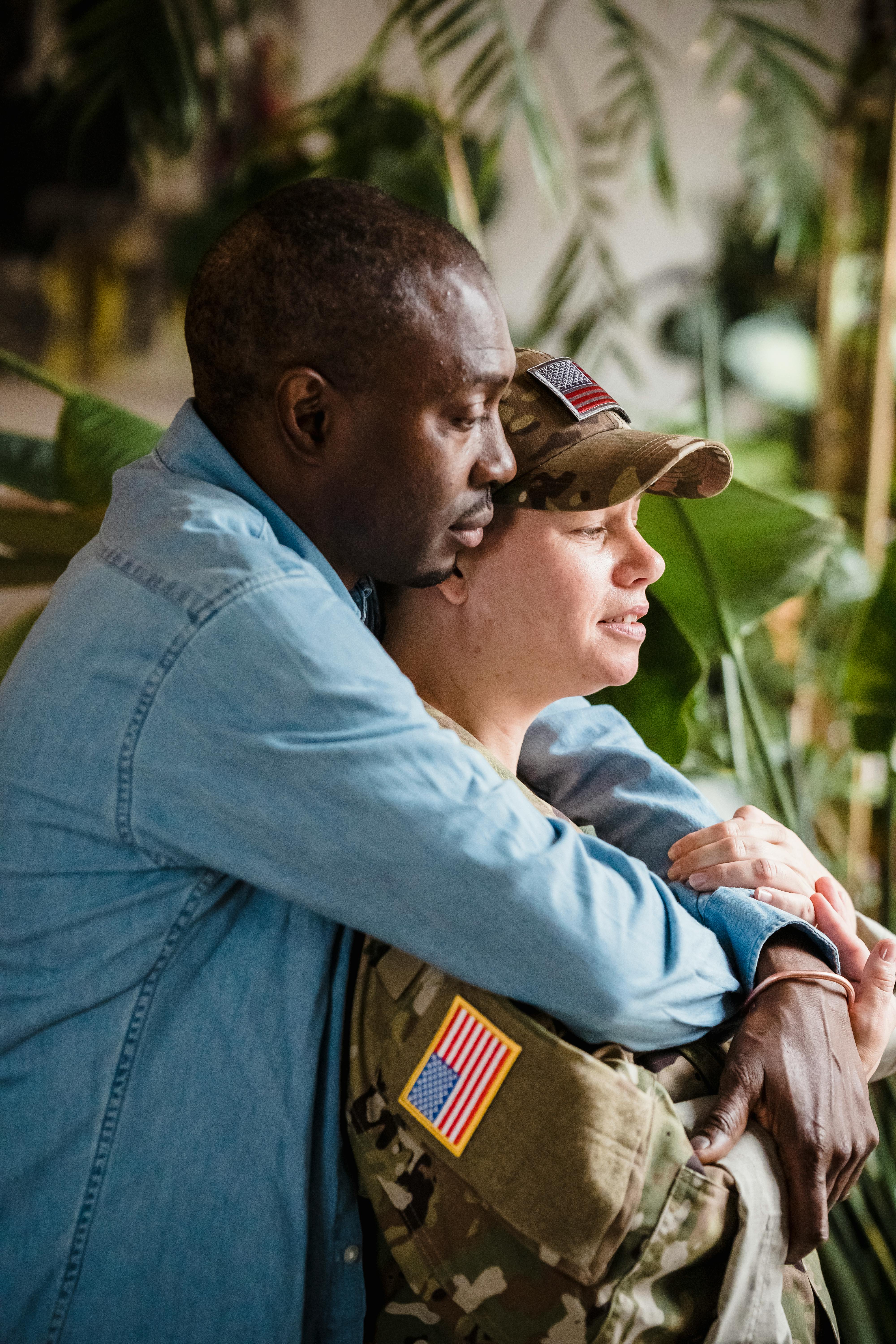 A Man in Blue Denim Jacket Hugging a Woman in Military Uniform · Free ...