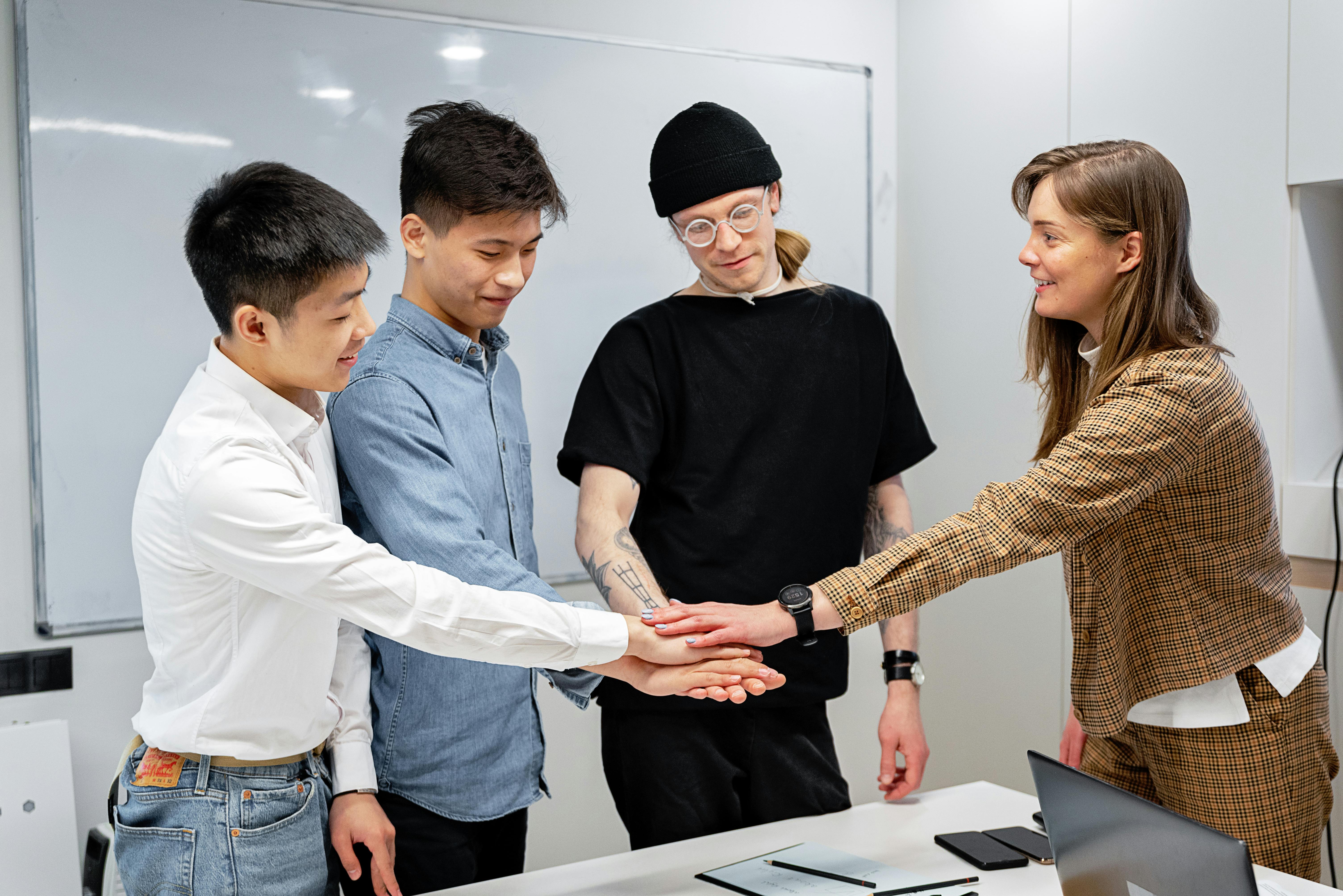 Employees Stacking Hands Inside the Office · Free Stock Photo