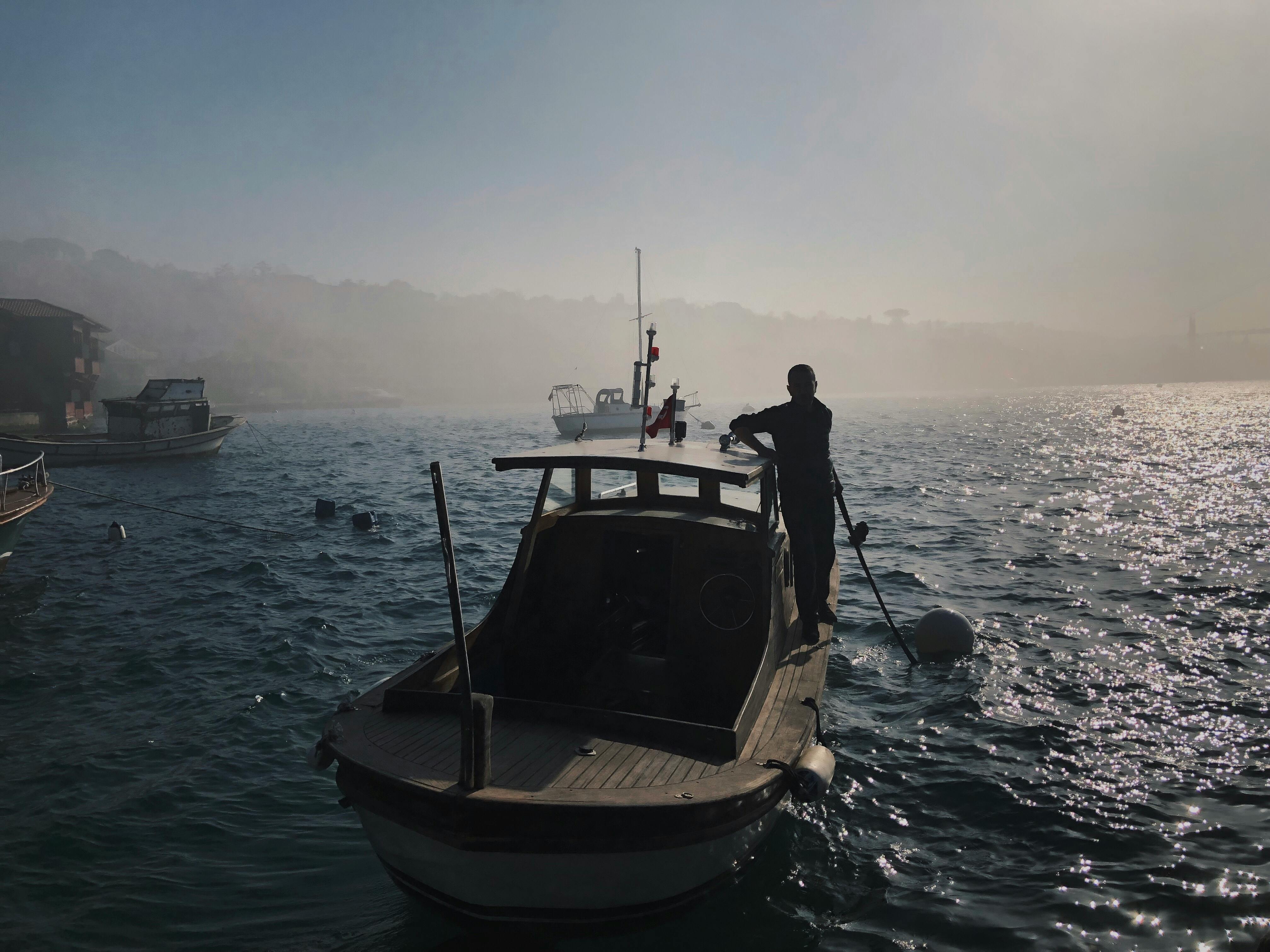 A Man Reading a Magazine Whole in a Boat Ride · Free Stock Photo