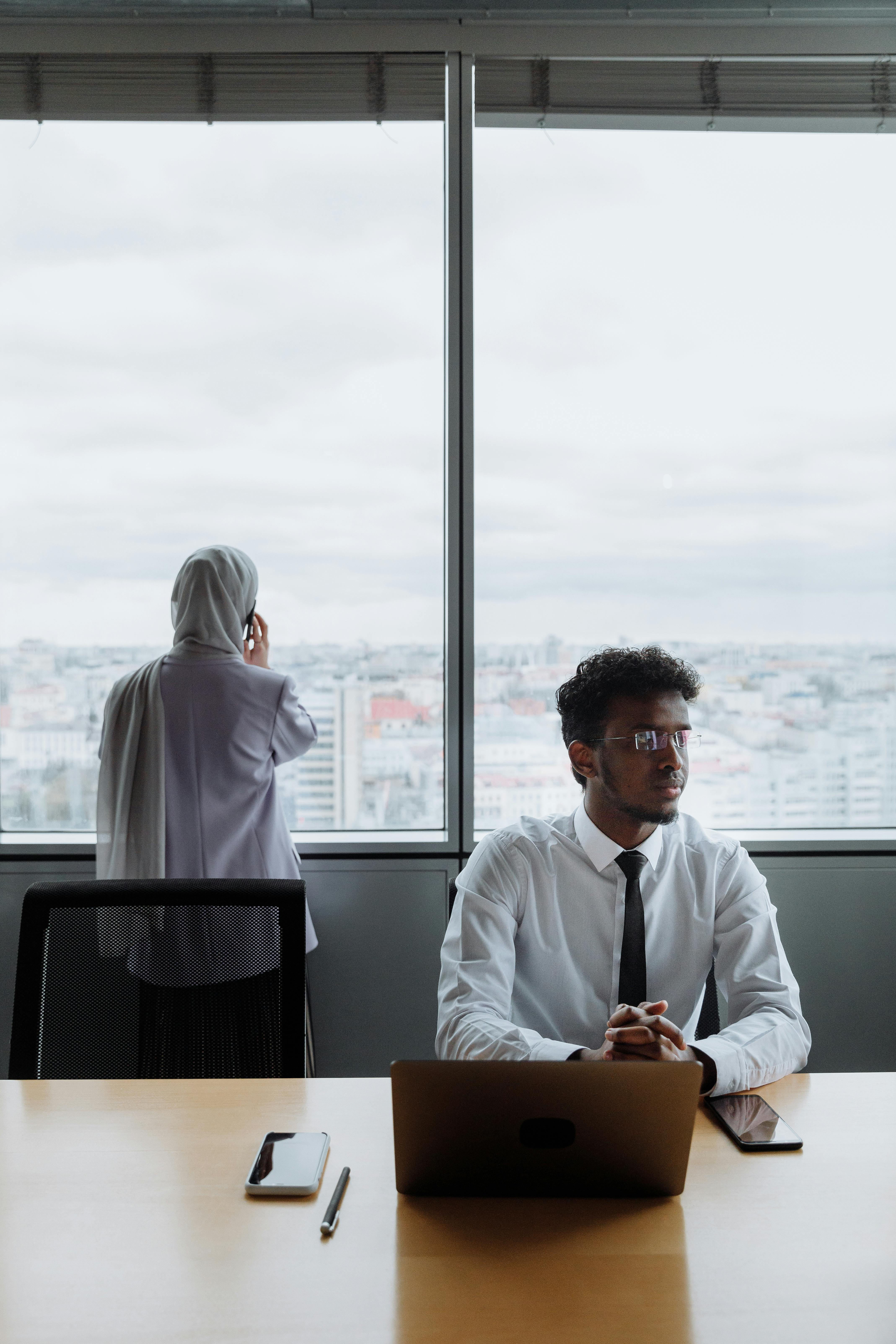 An Employee on a Phone Call while Facing the Window · Free Stock Photo