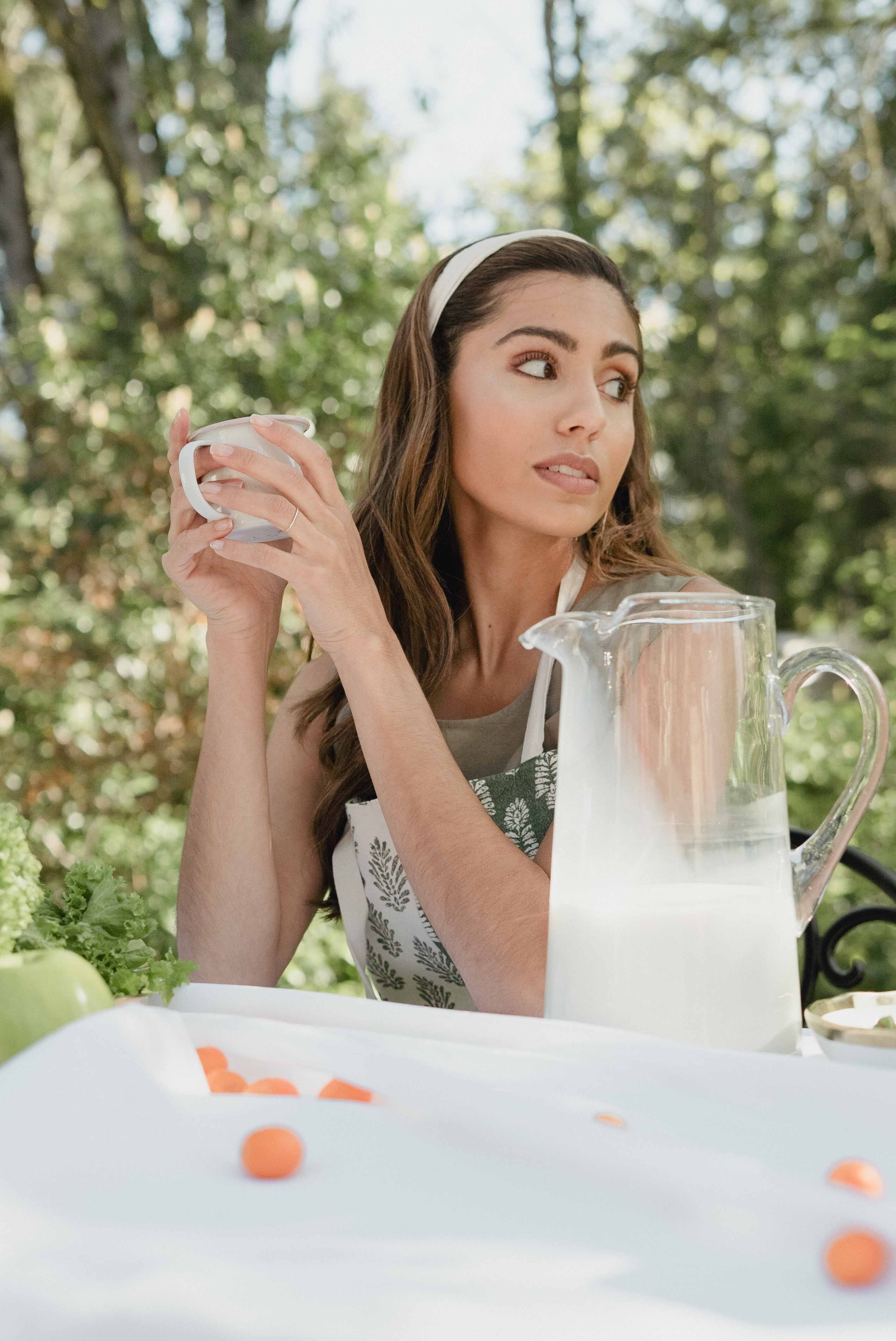 A Woman Holding a Cup Looking Sideways · Free Stock Photo