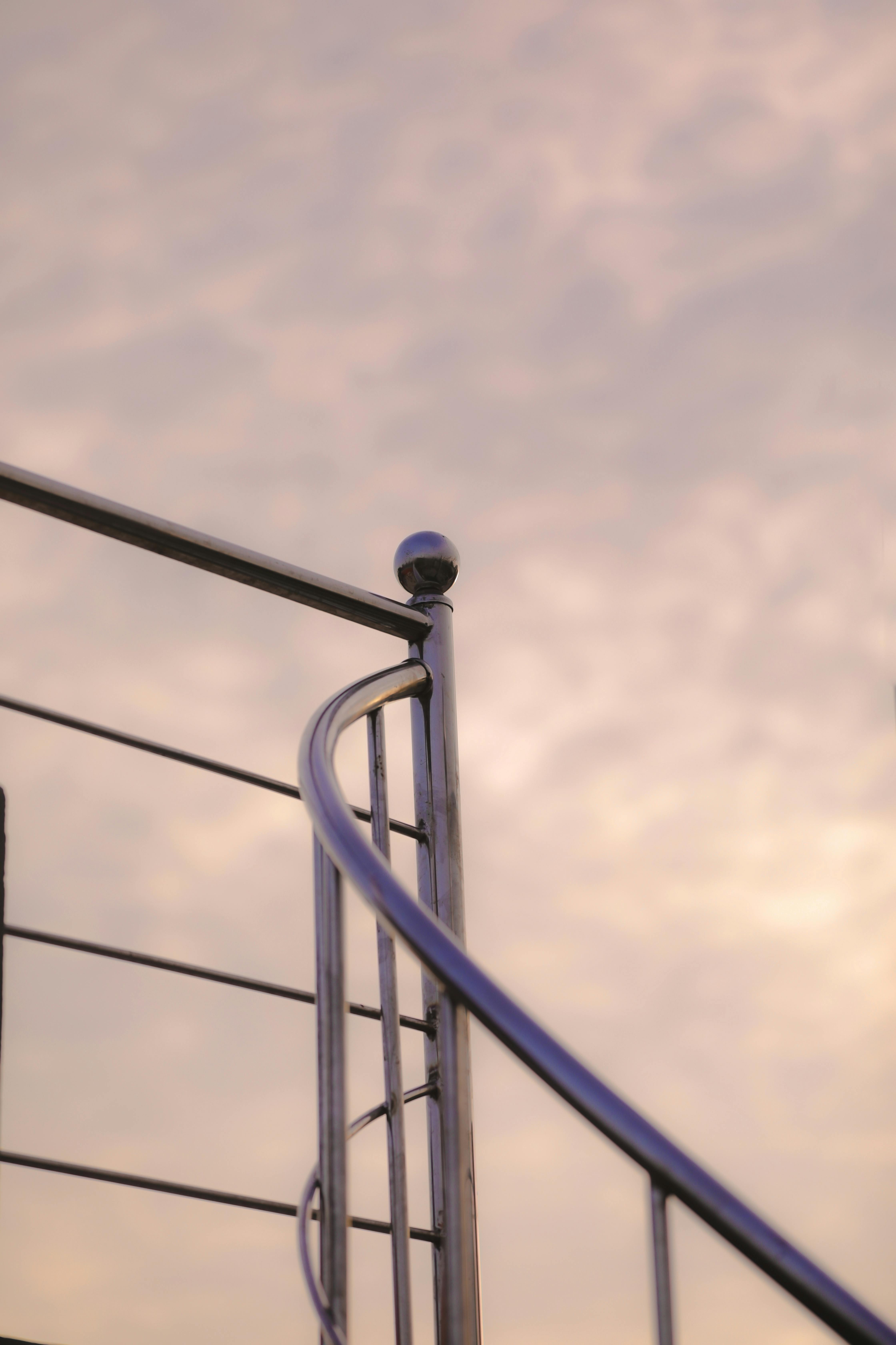 Metal railing against cloudy sky · Free Stock Photo