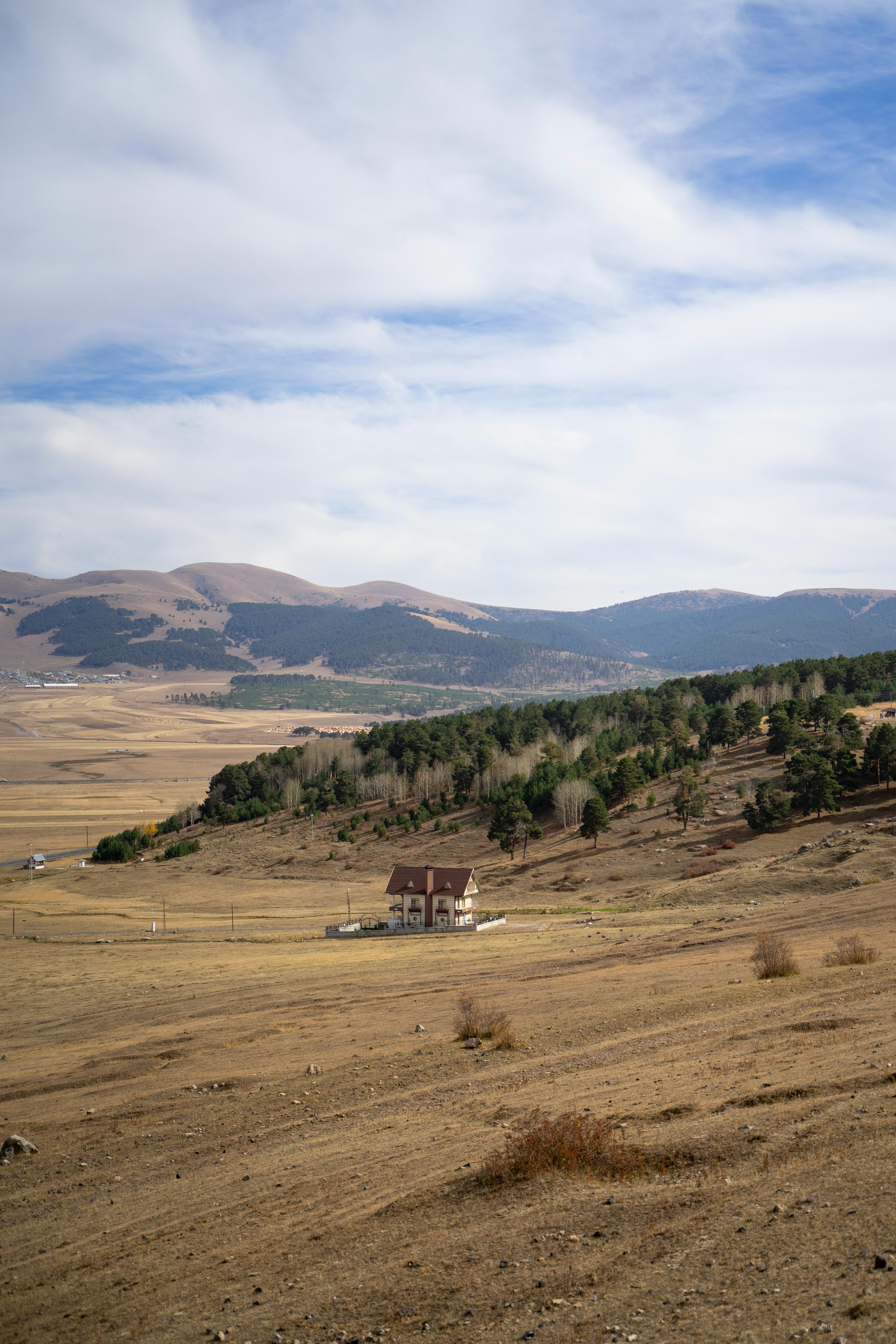 Farmhouse with Hills and Trees in the Distance · Free Stock Photo