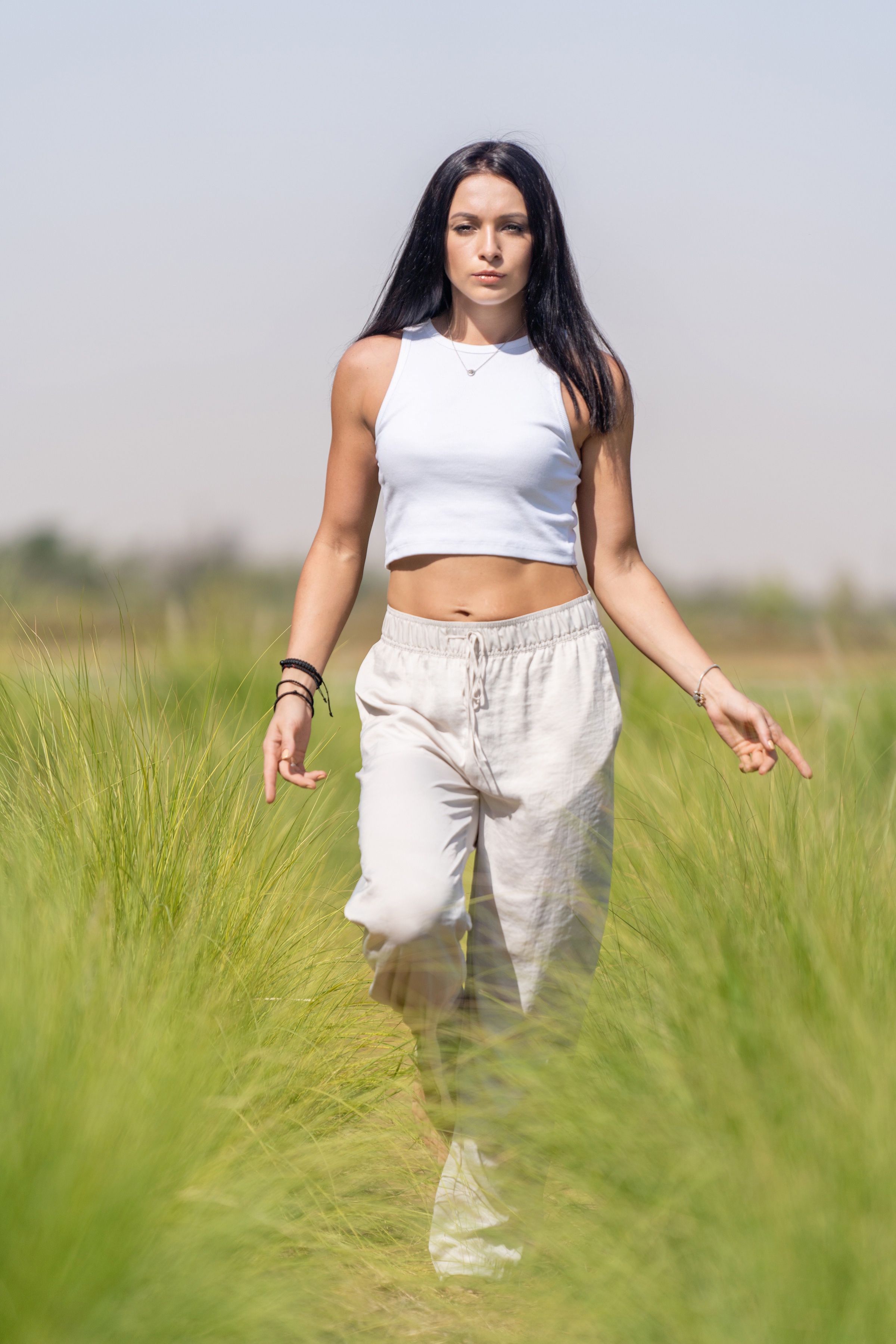 Woman Walking on Grass Field · Free Stock Photo