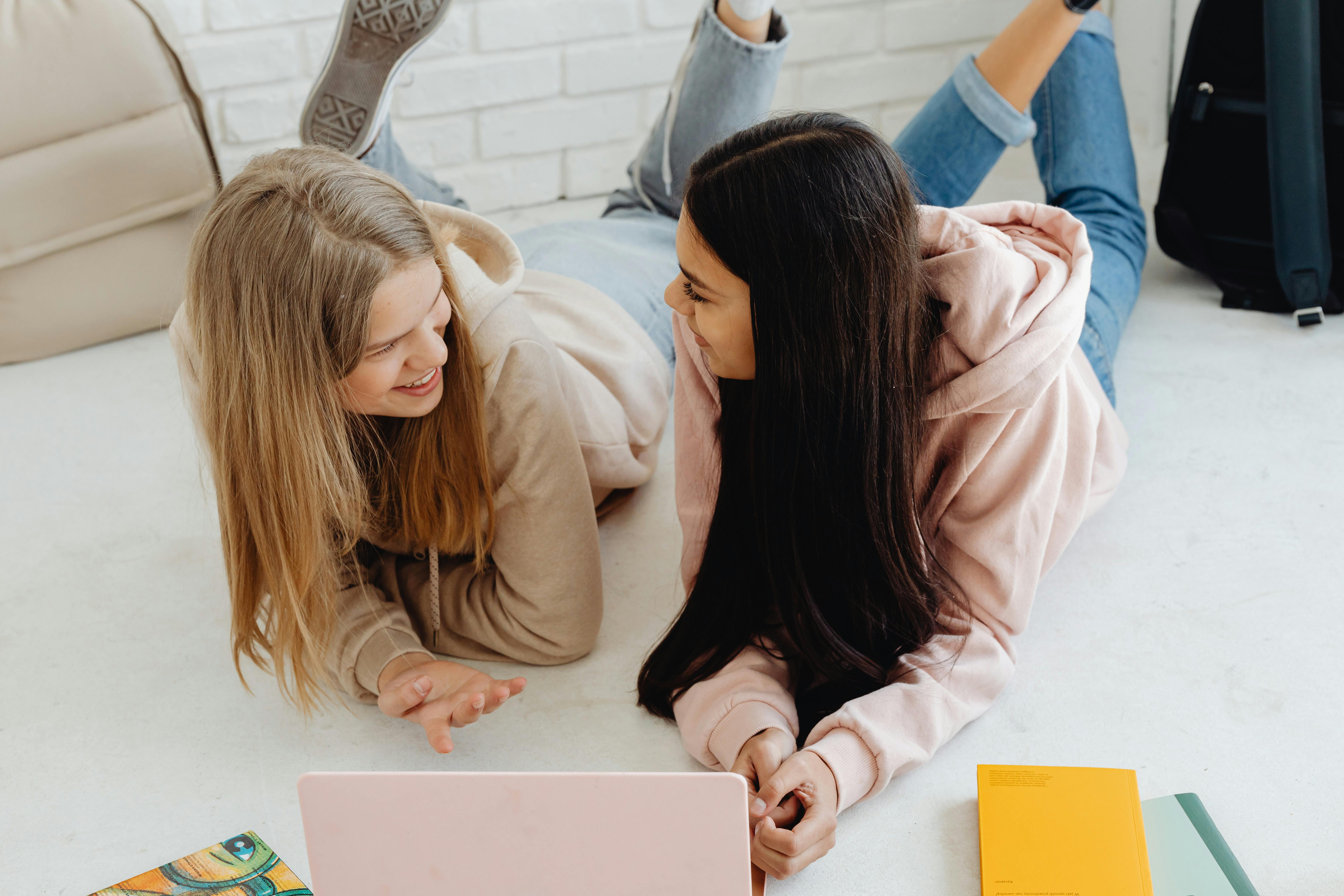 Two Girls having a Conversation while Lying Down on the Bed · Free ...
