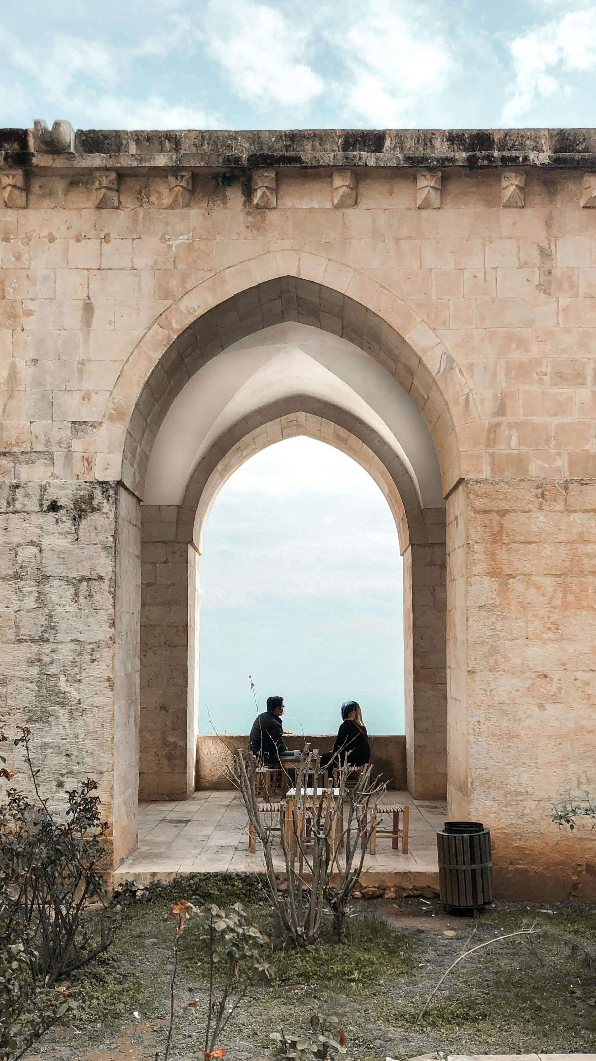 Person Standing under an Arch on the Side of a Fortress · Free Stock Photo