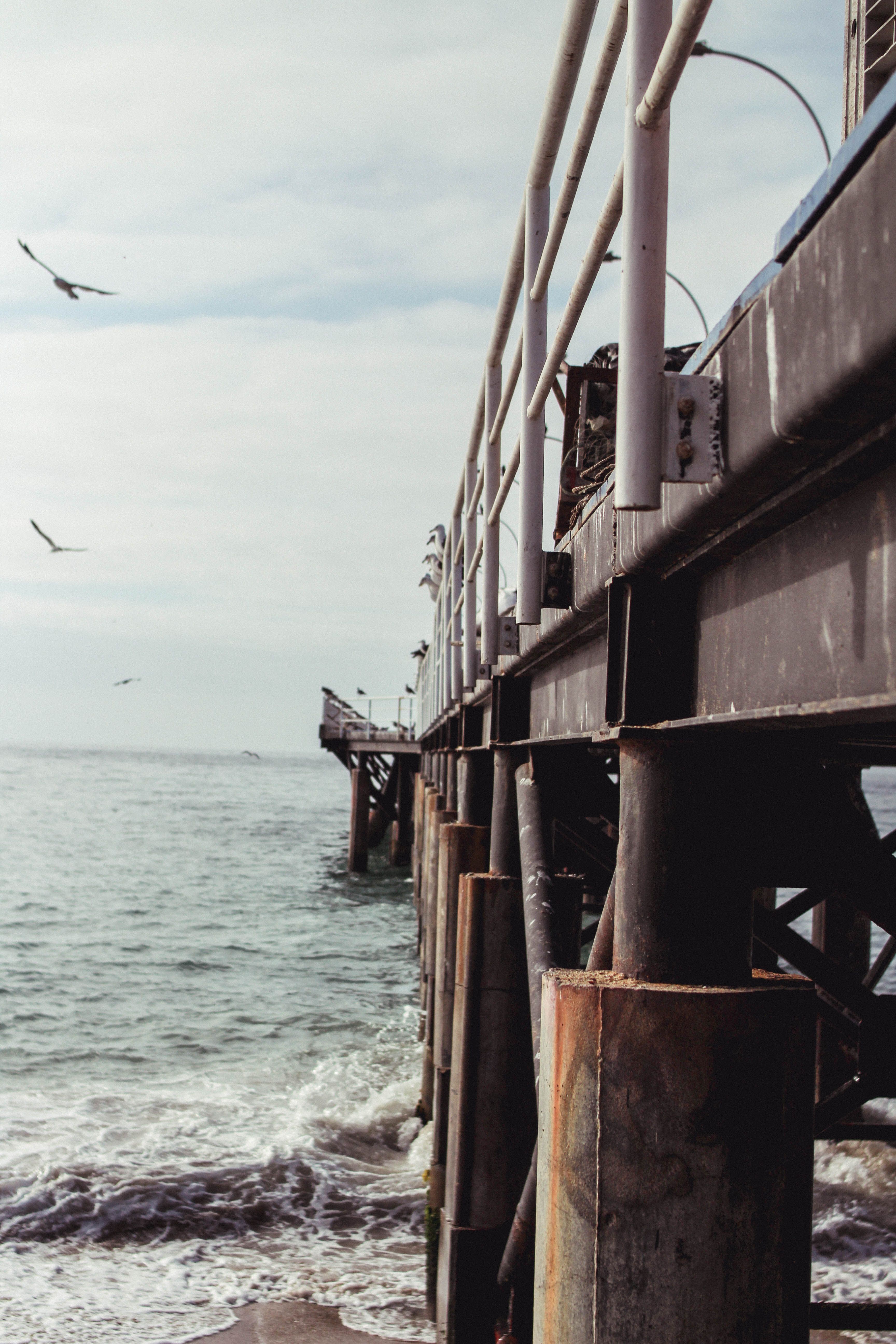 Ocean Waves Crashing on Rusty Metal Dock · Free Stock Photo