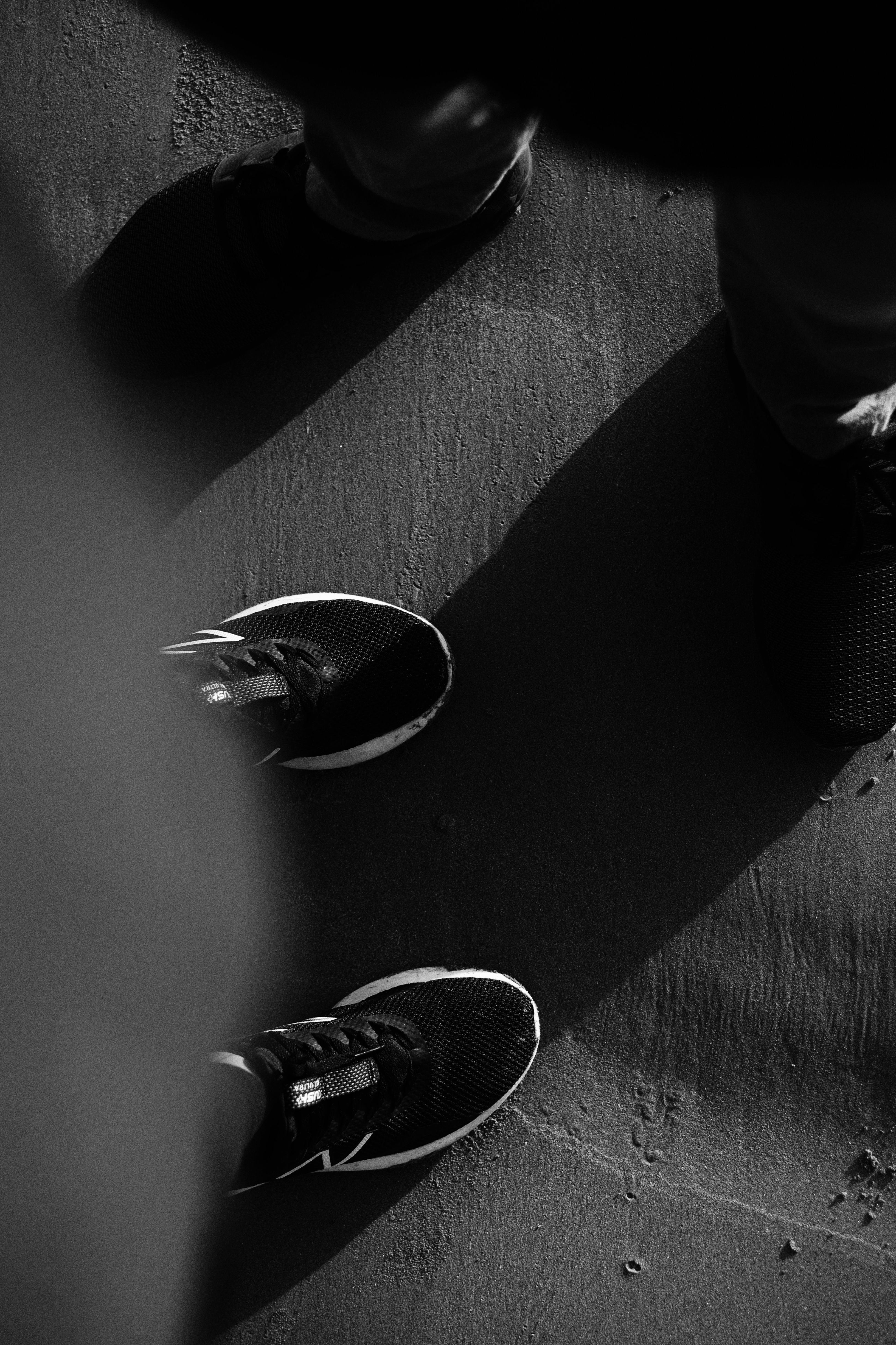 Grayscale Photo of a Person Wearing Sneakers · Free Stock Photo