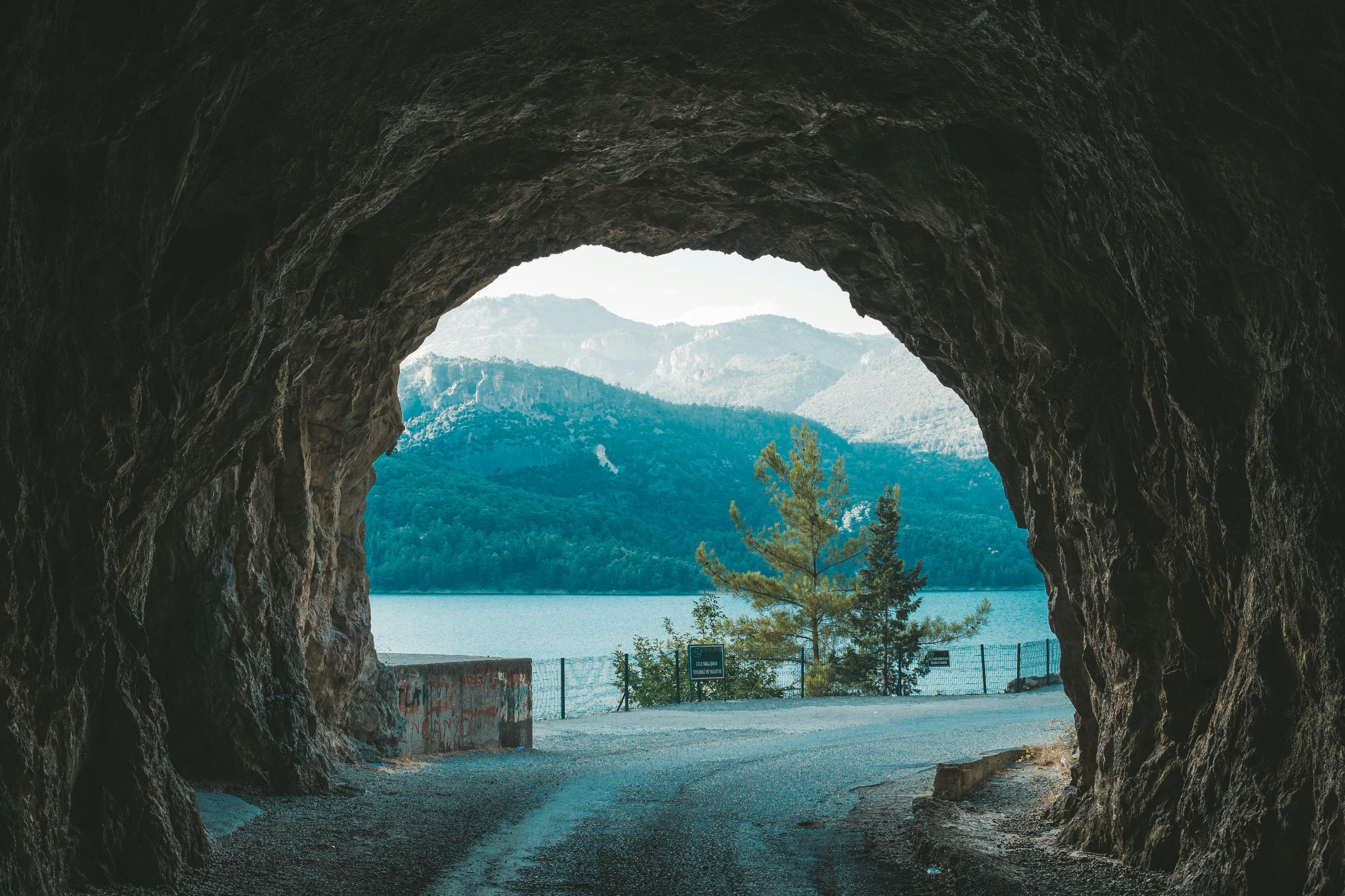 Road through a Rock Tunnel and Landscape with Lake · Free Stock Photo