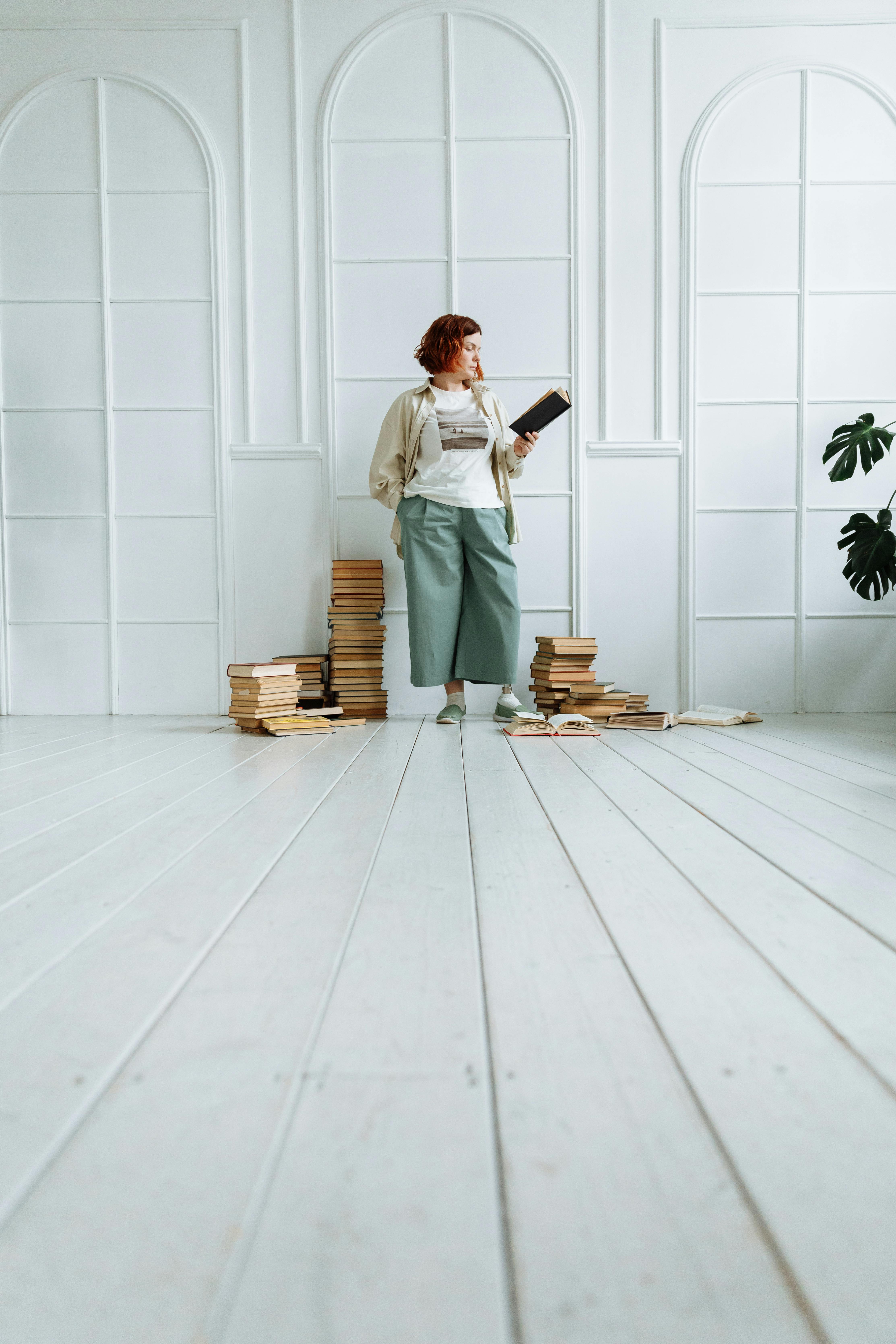 A Woman Standing while Reading a Book · Free Stock Photo