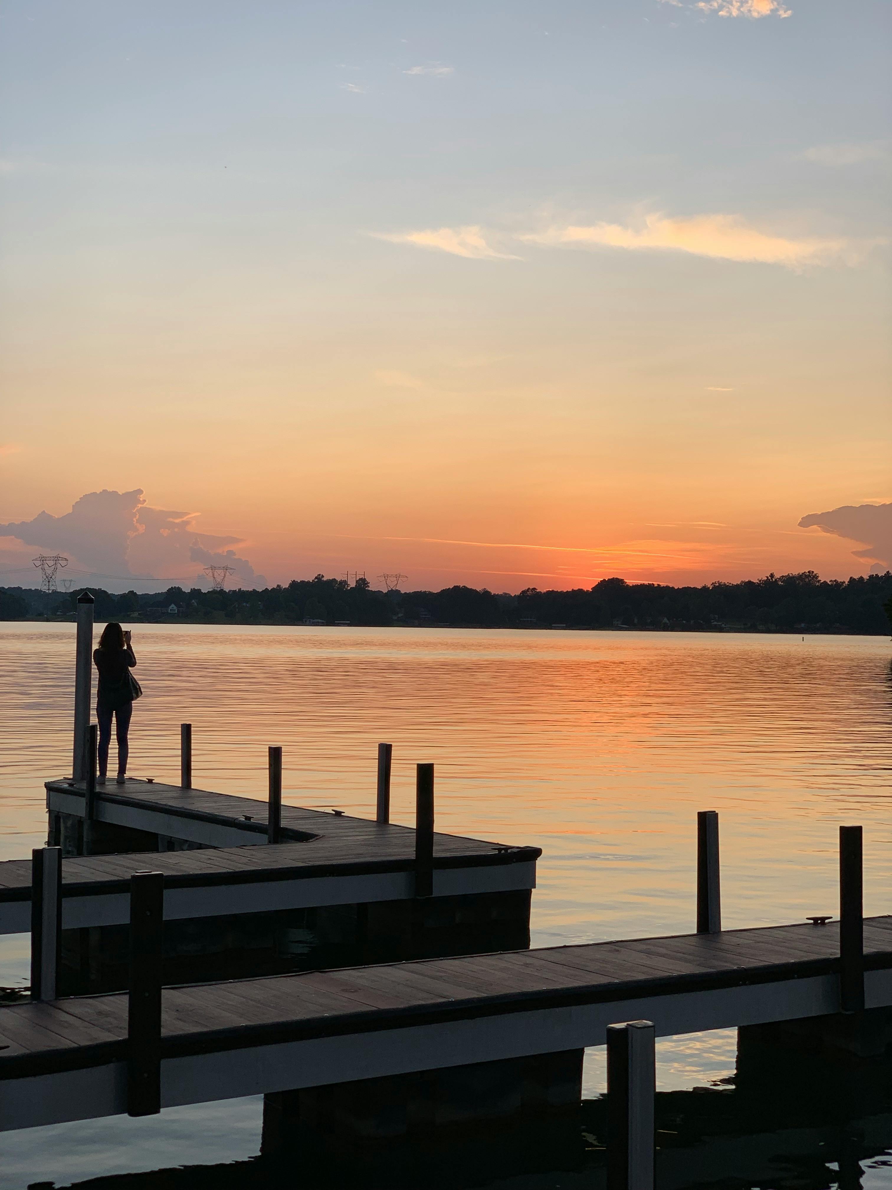 Man Standing on River Dock during Sunset · Free Stock Photo