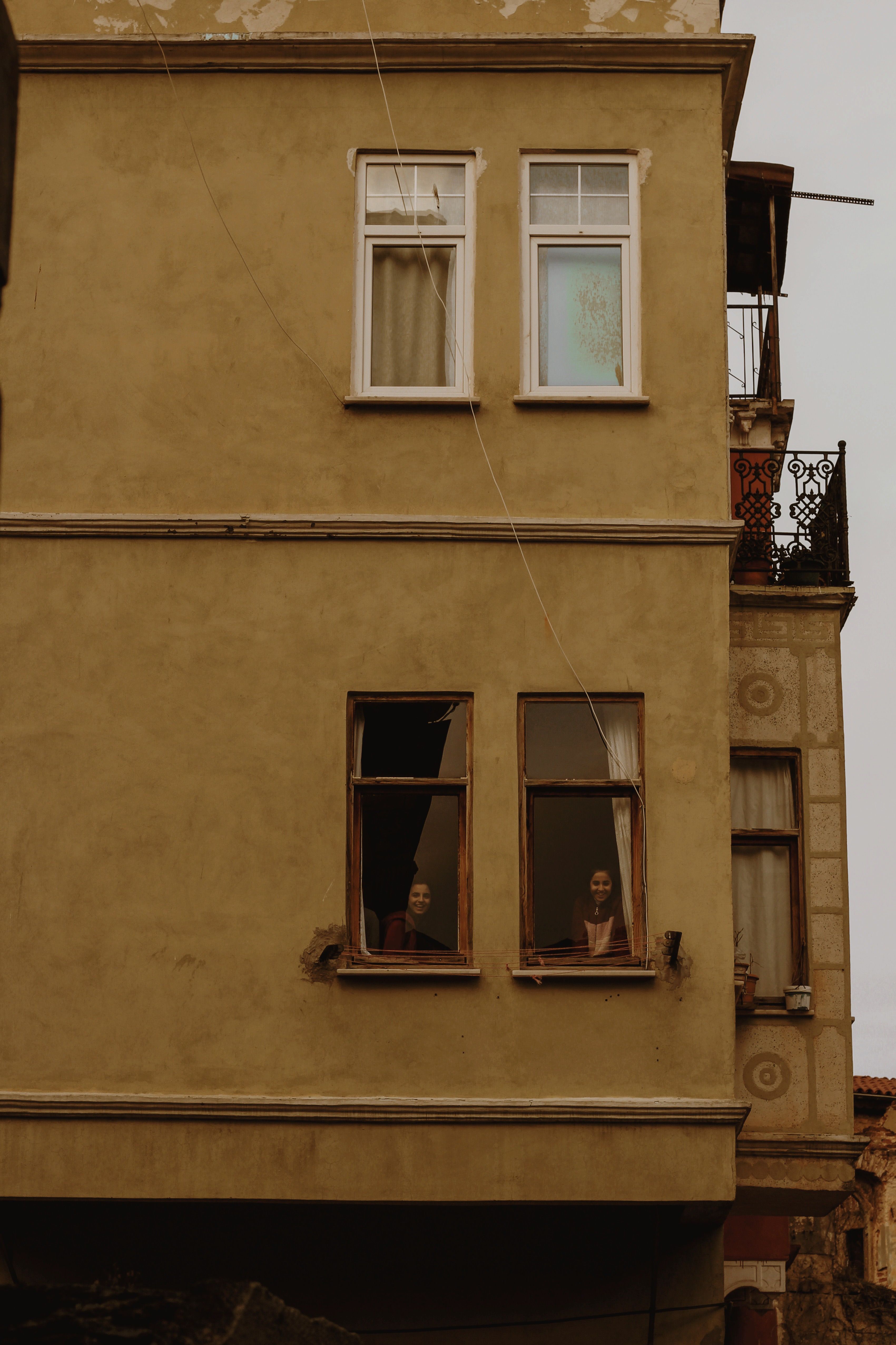 People Looking Out of Their Windows in a Block of Flats · Free Stock Photo