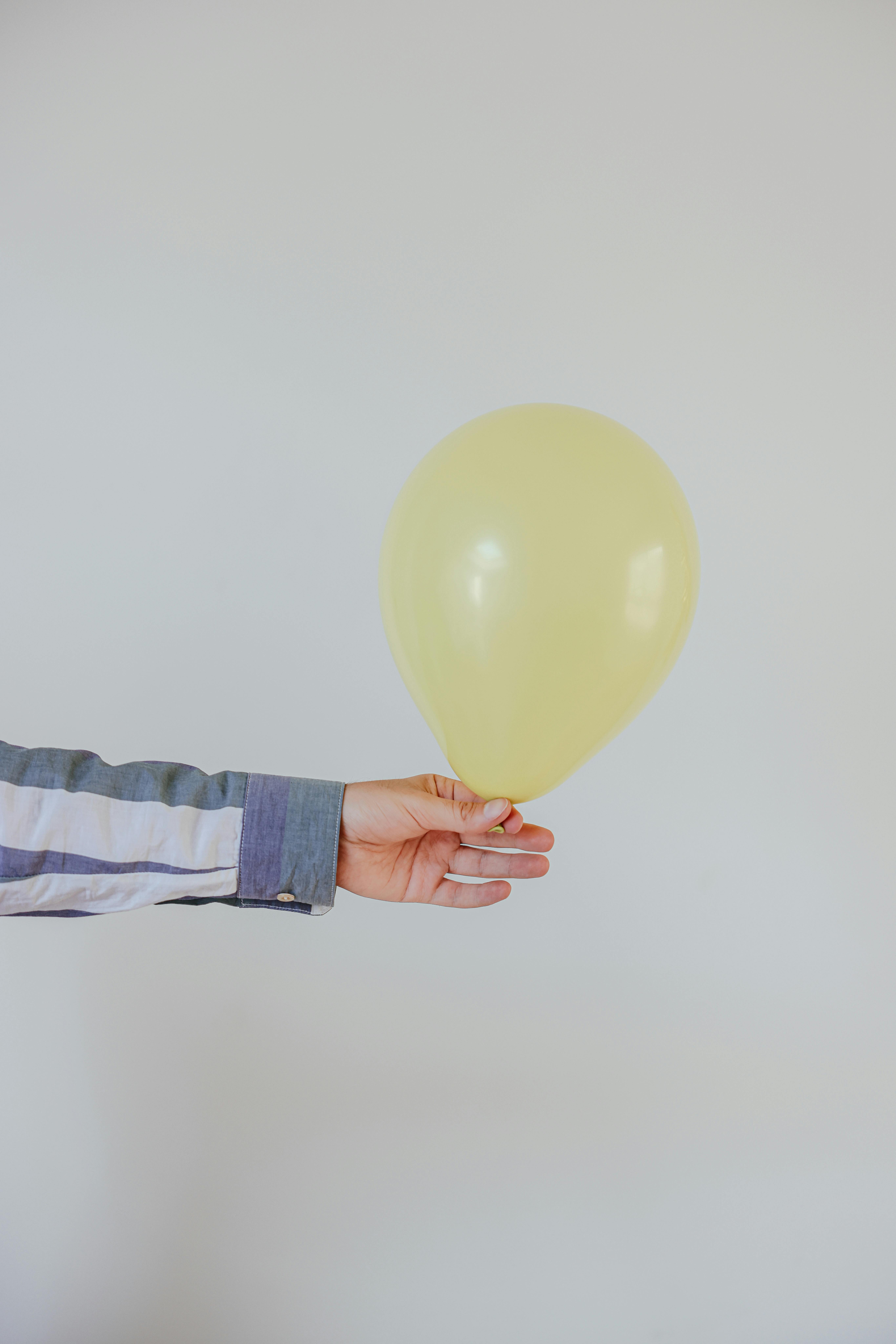 Person Holding a Yellow Balloon · Free Stock Photo