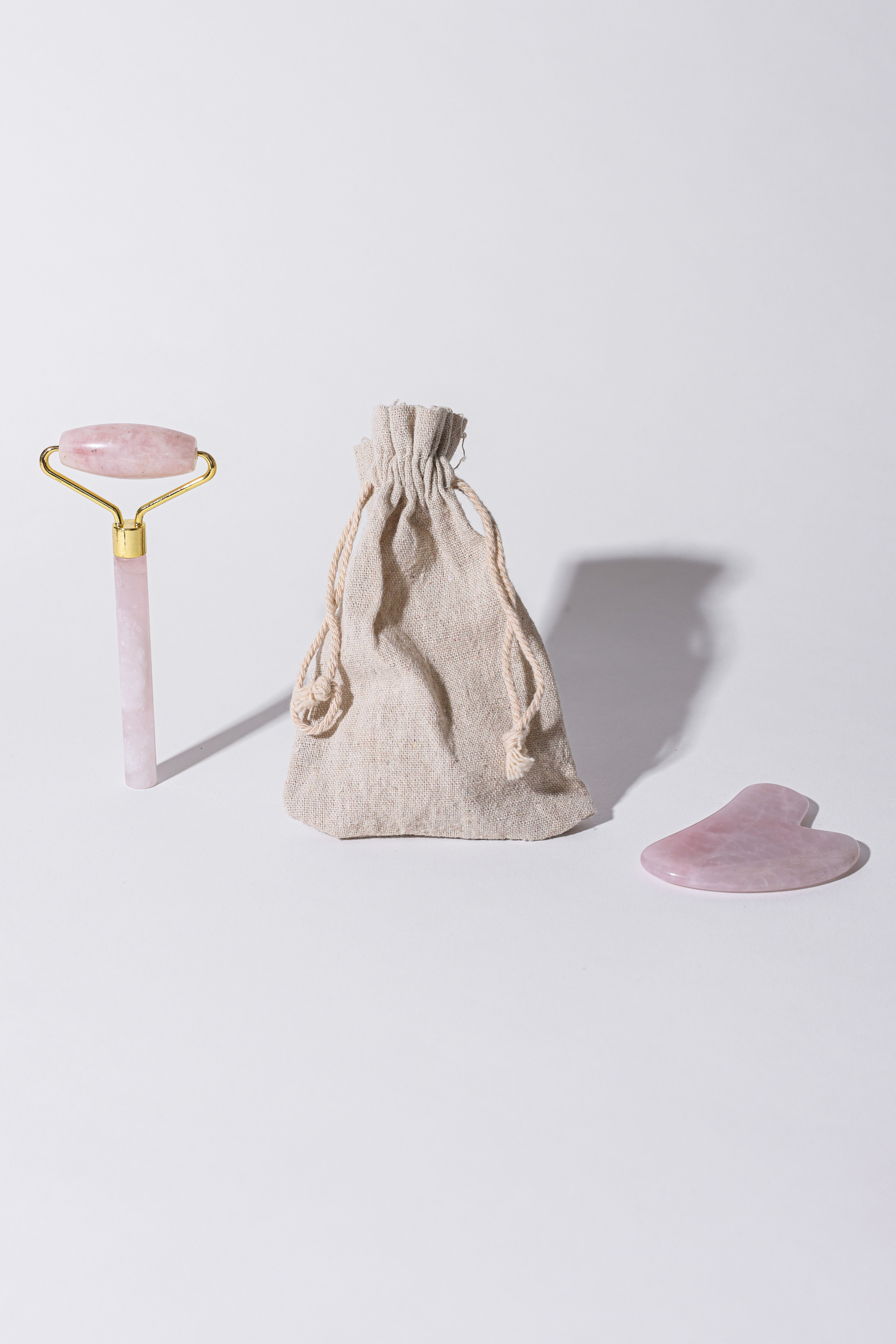 A Linen Pouch Beside a Pink Jade Roller · Free Stock Photo