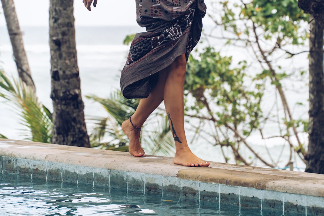 Unrecognizable Woman Walking Along Poolside In Tropical Resort · Free