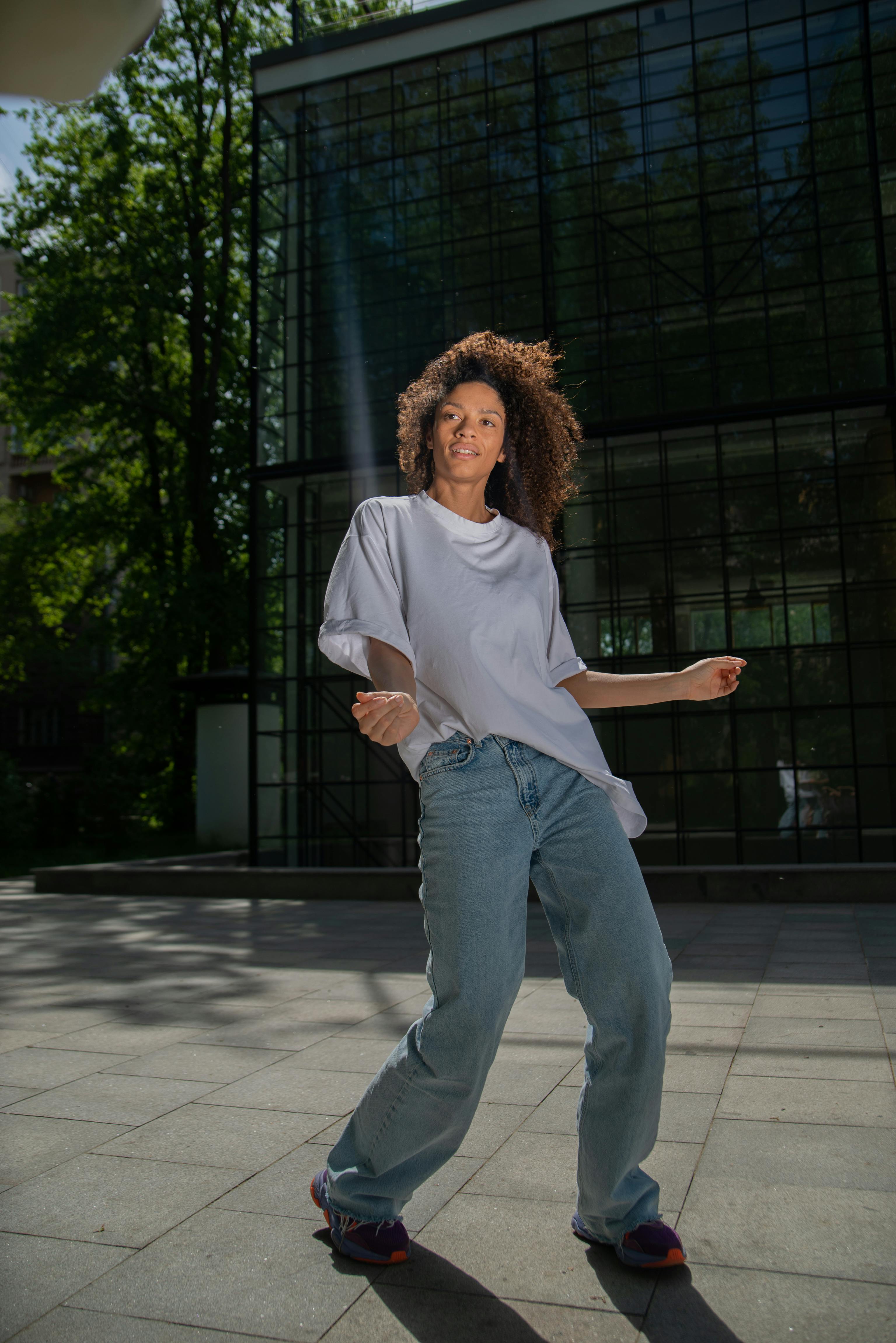 A Smiling Woman Crouching on Pavement · Free Stock Photo