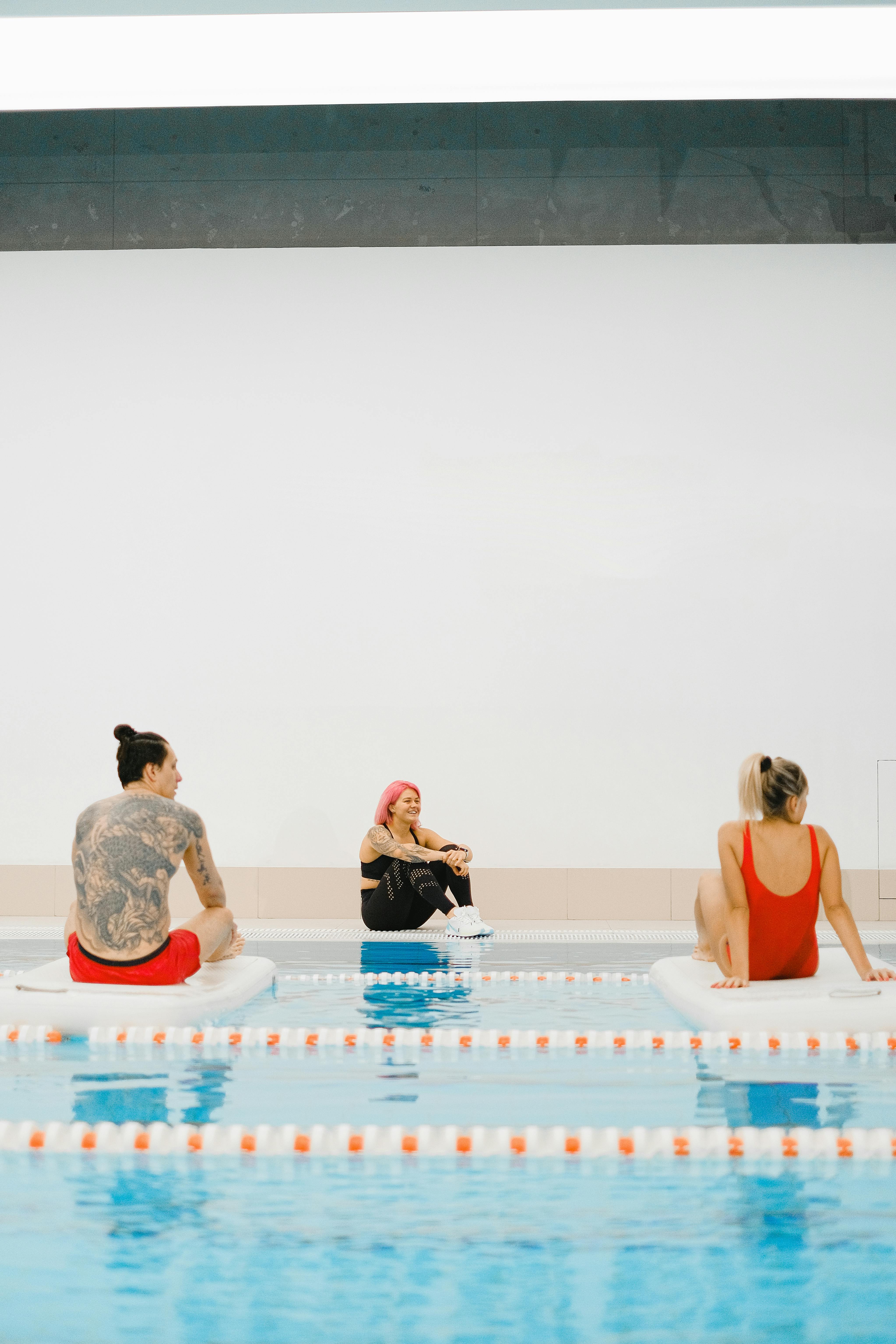 People Sitting on Swimming Boards in a Swimming Pool · Free Stock Photo
