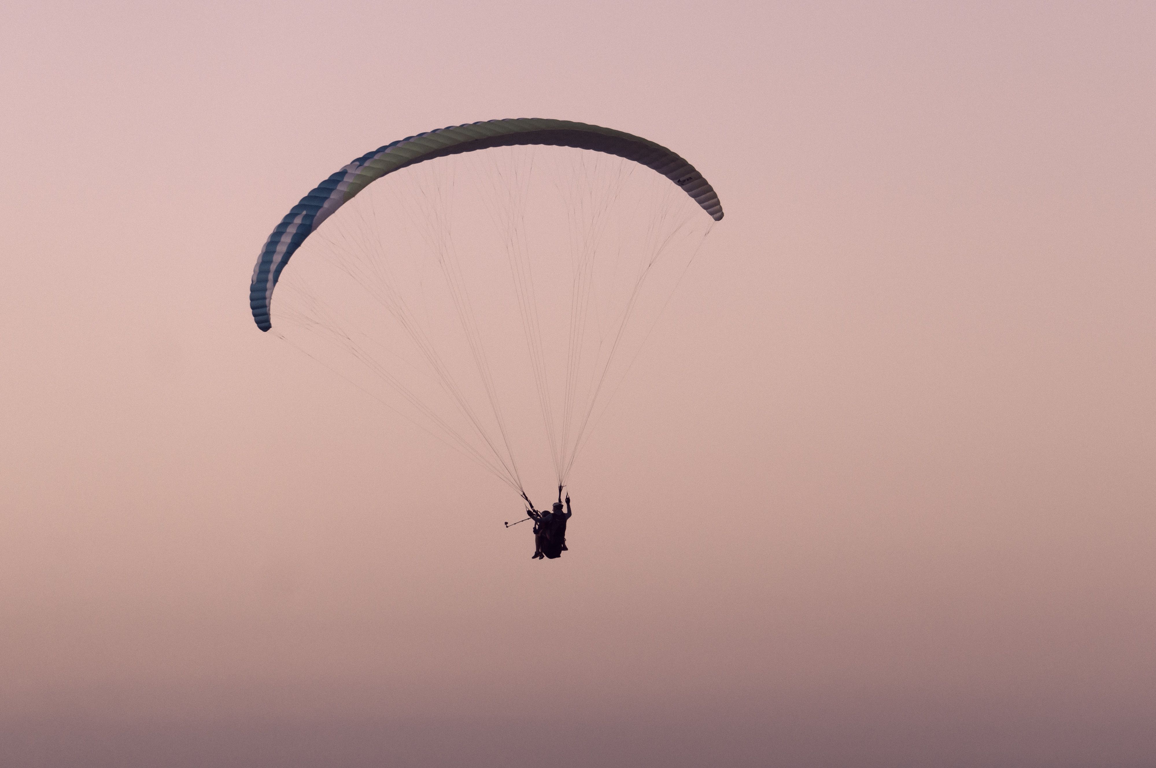 Person in Parachute Gliding Above Mountains · Free Stock Photo