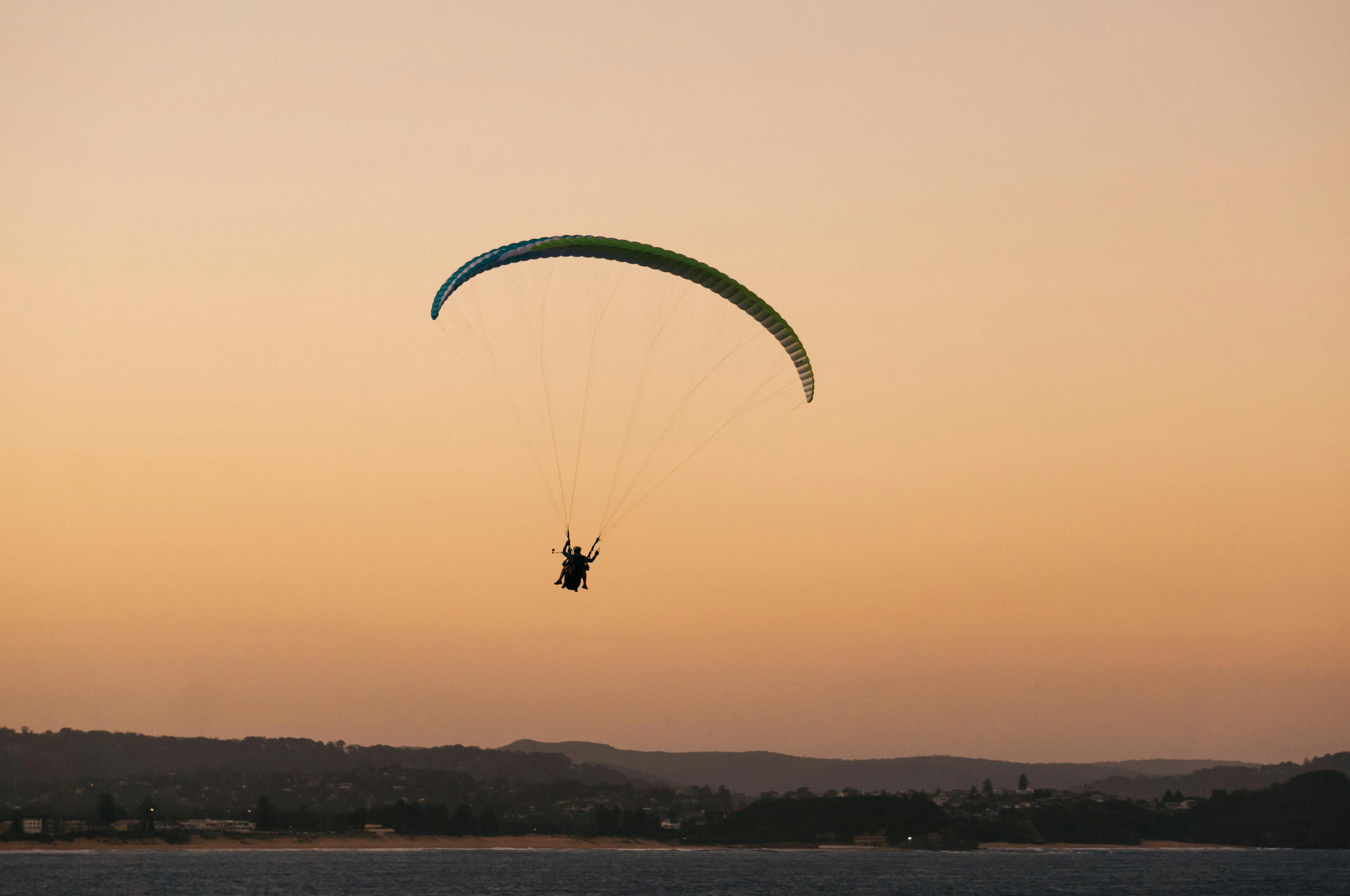Paraglider in the Sky Above Water During Sunset · Free Stock Photo