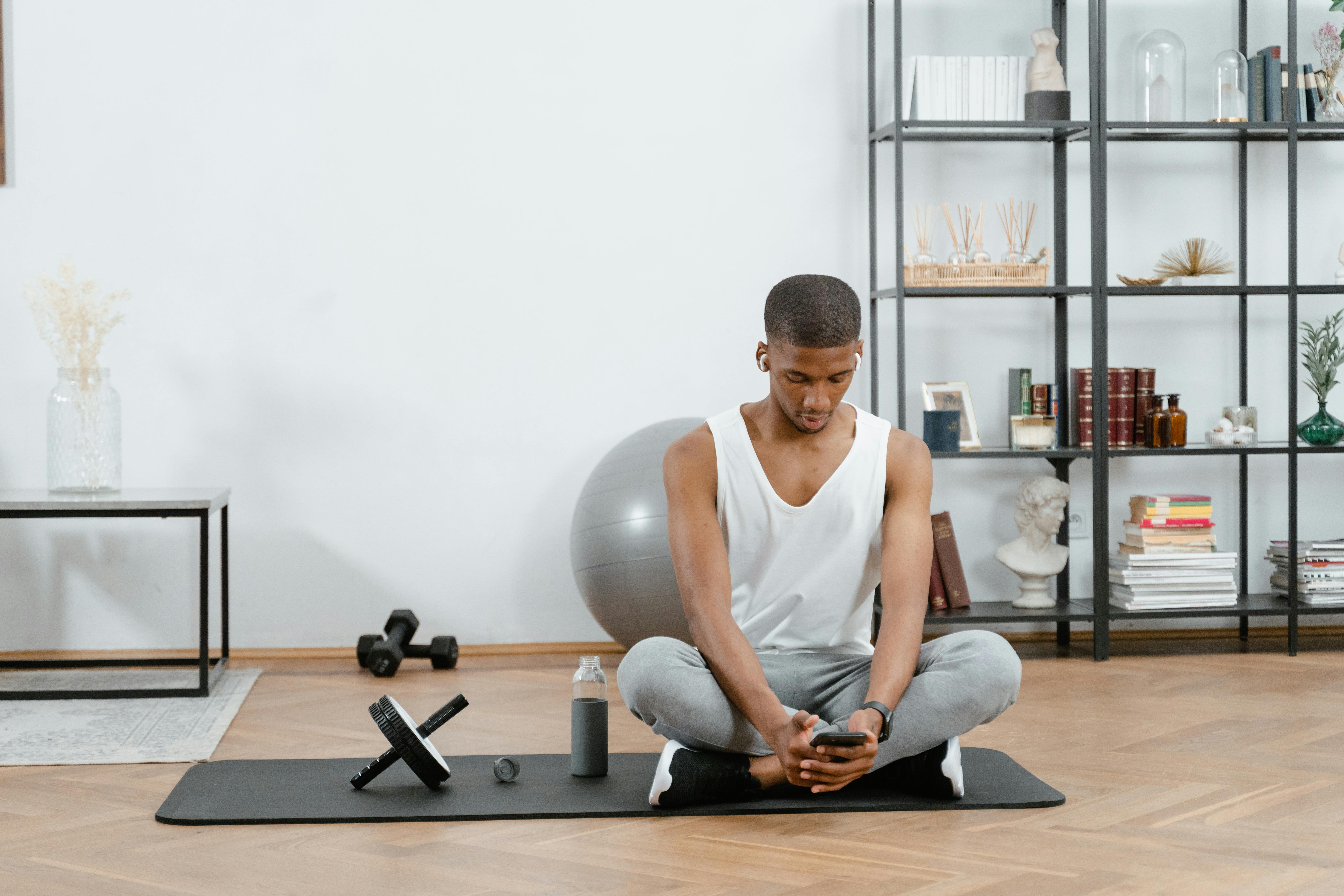 Man Sitting on a Yoga Mat · Free Stock Photo