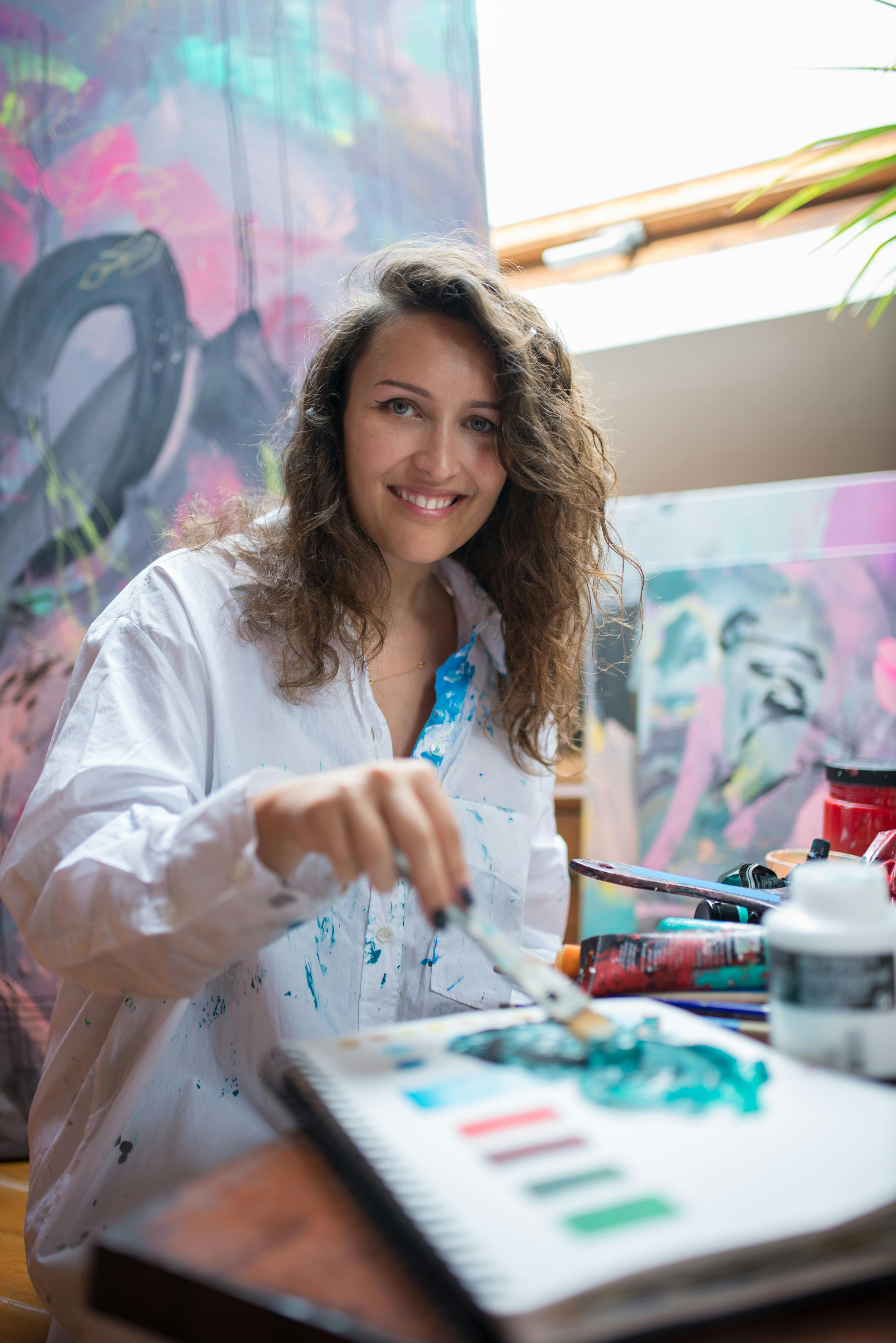 Portrait of Smiling Artist Painting in Studio · Free Stock Photo