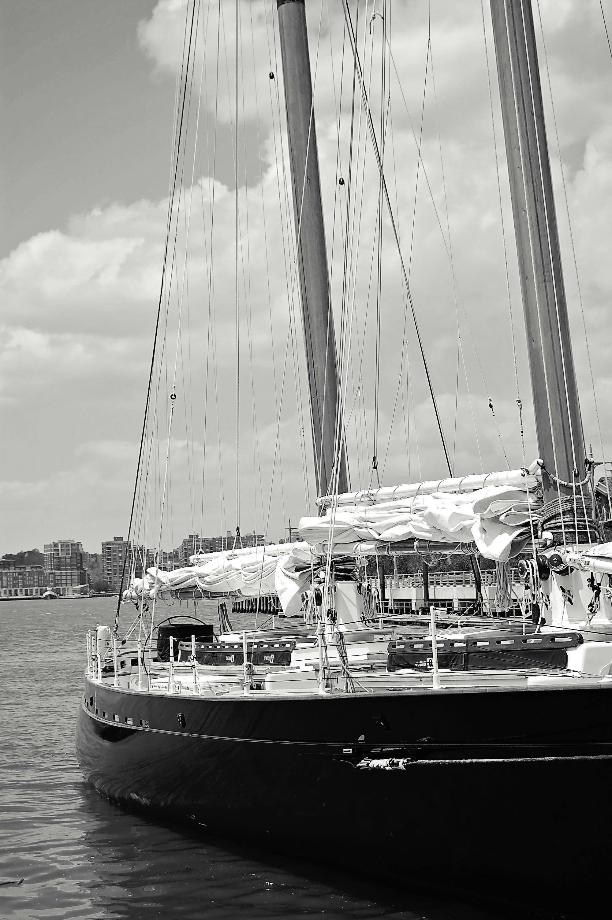 Grayscale Photo of Ship Near High-rise Mountains · Free Stock Photo