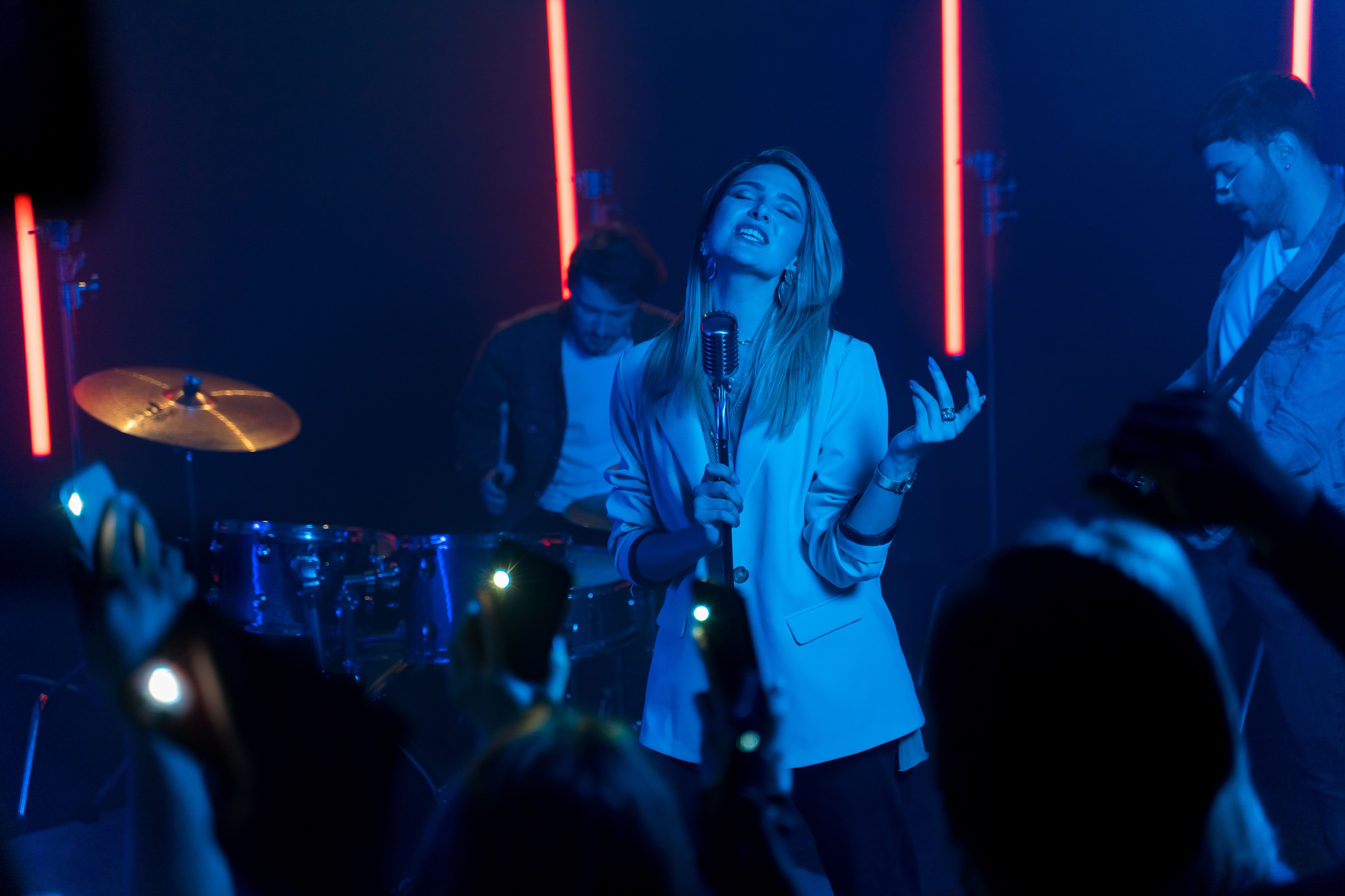 A Vocalist Holding a Microphone and Singing · Free Stock Photo