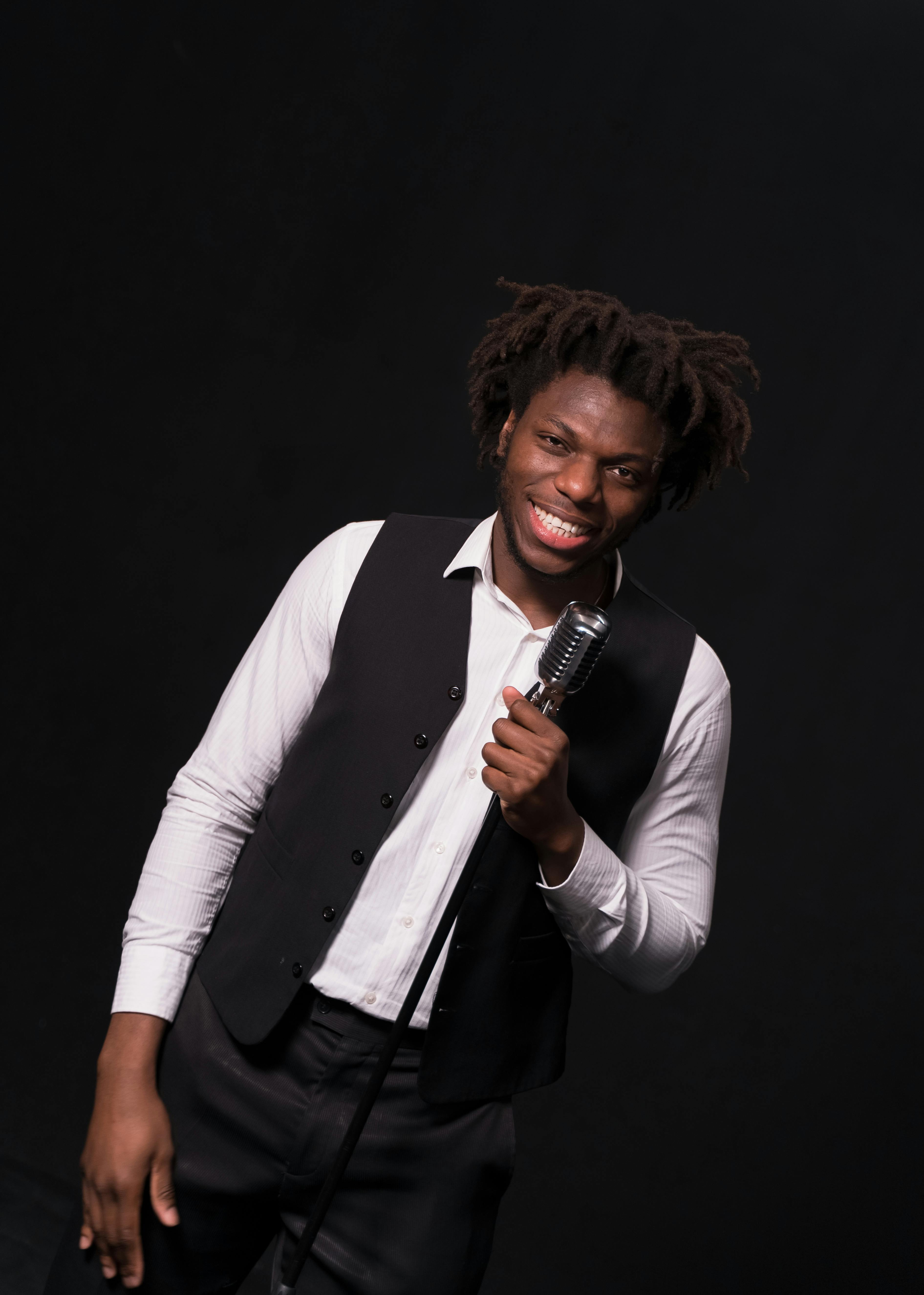 Smiling Man Holding a Microphone · Free Stock Photo