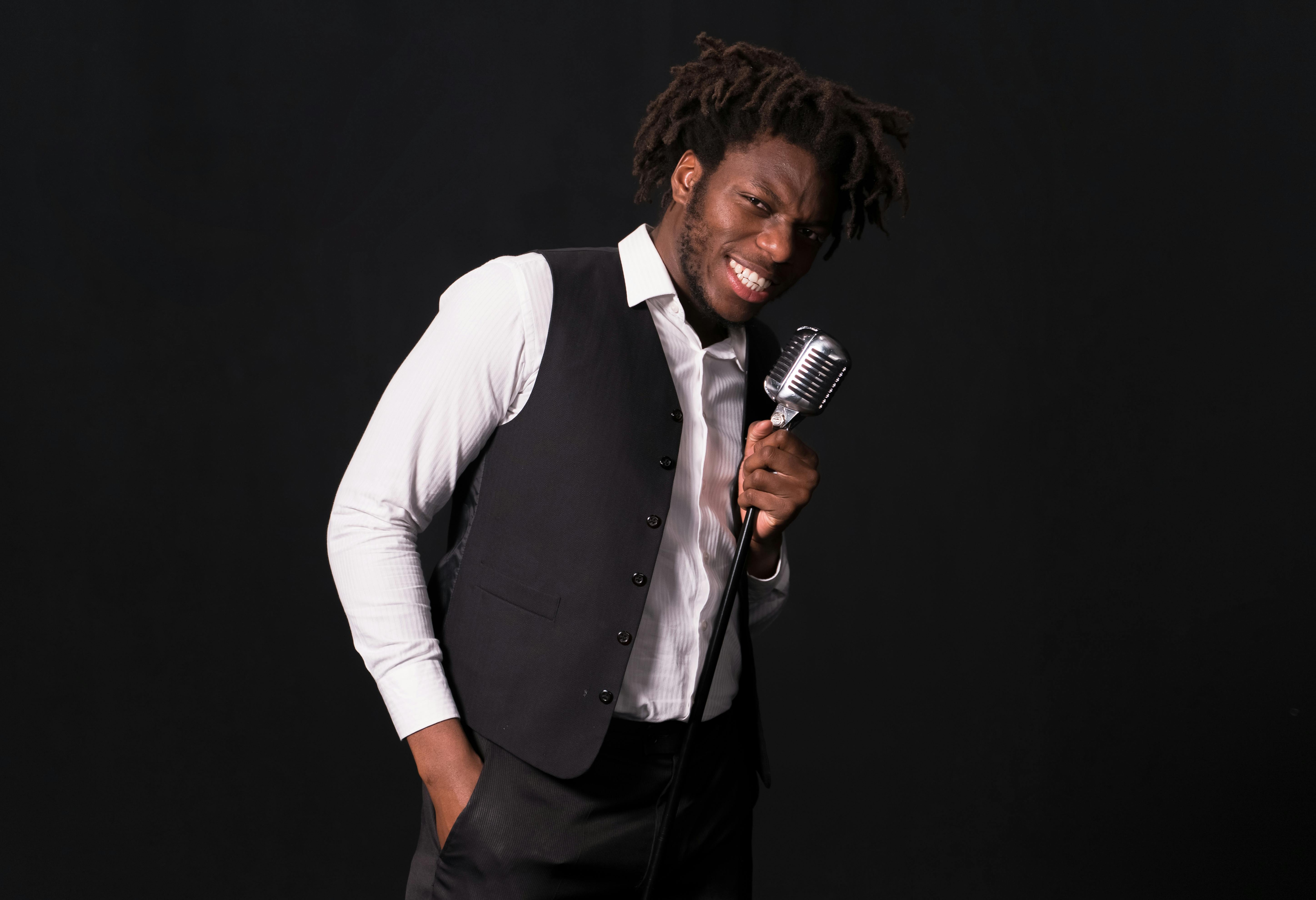 A Man in Gray Suit Holding a Microphone · Free Stock Photo