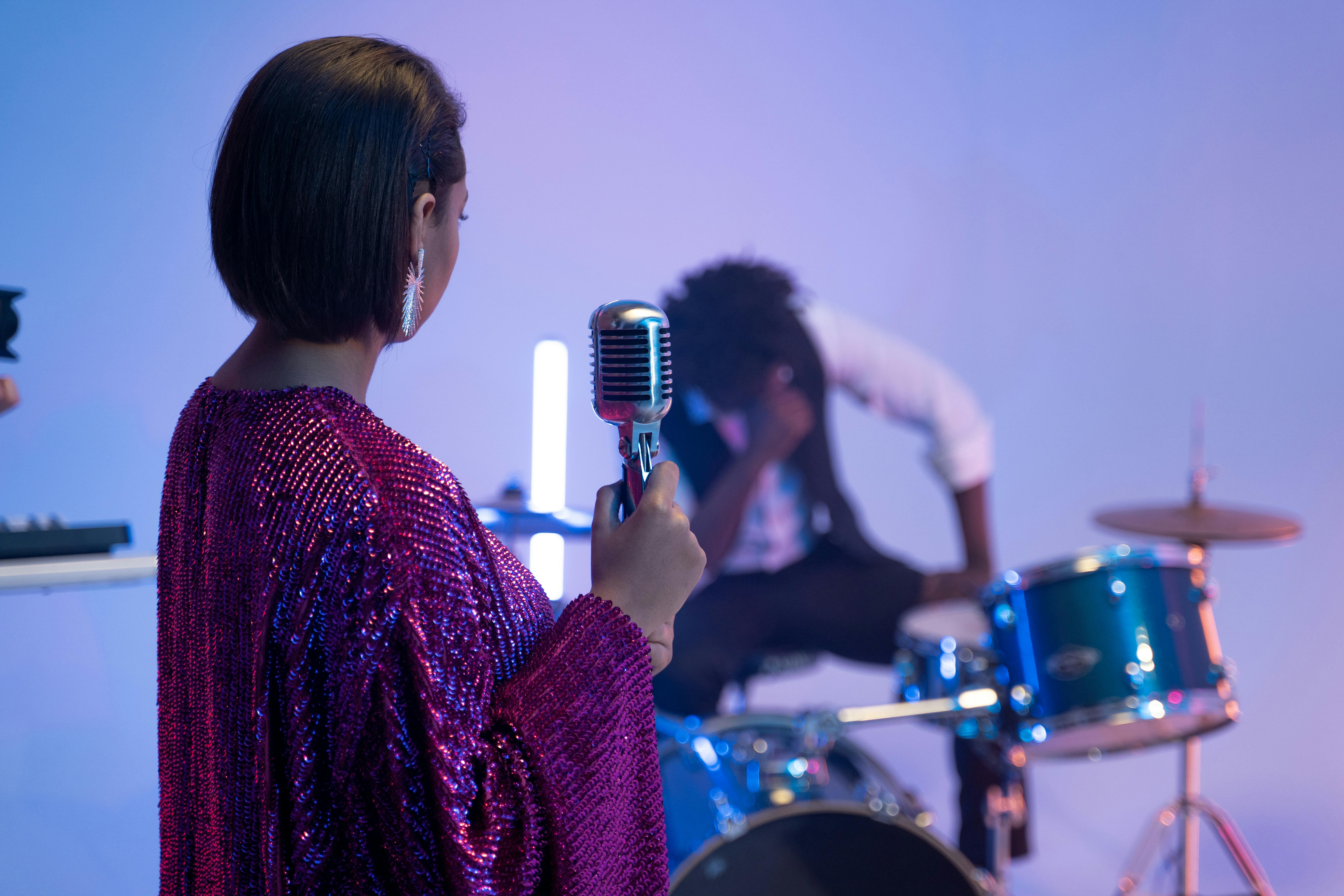 A Female Singer Holding a Microphone · Free Stock Photo