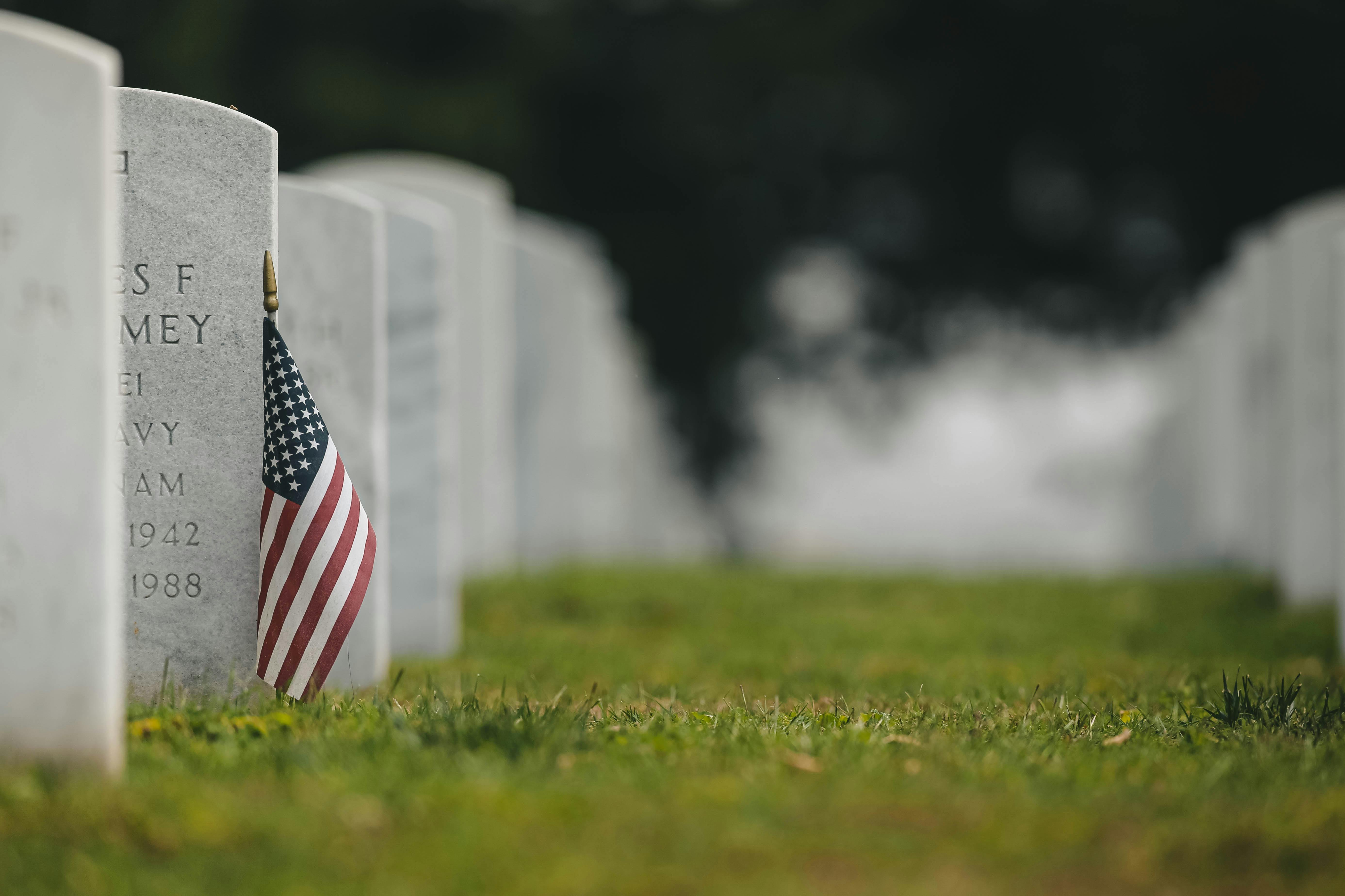 American Flag Near the Tombstone on the Green Grass · Free Stock Photo