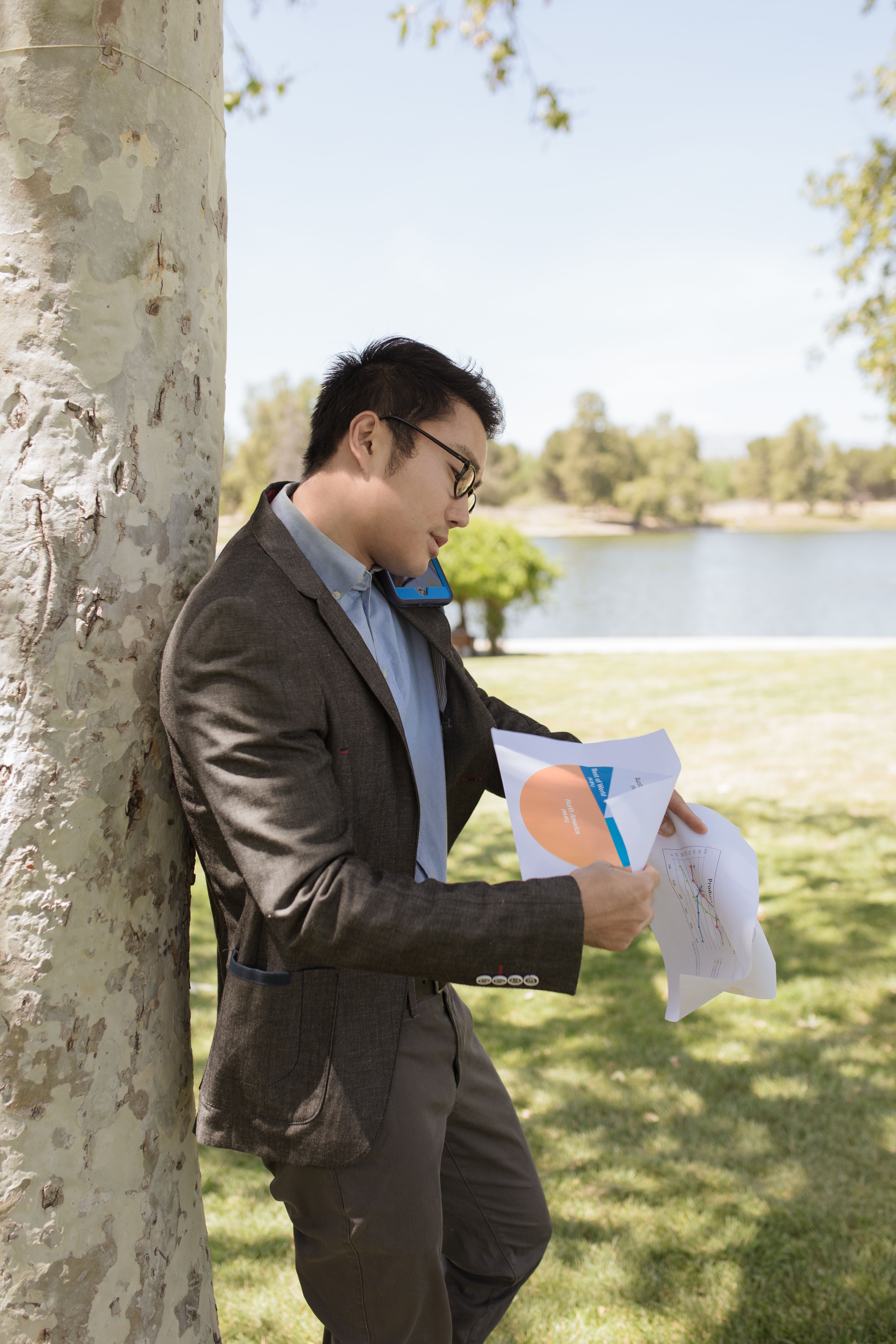 Man Talking on the Phone While Holding Paper · Free Stock Photo