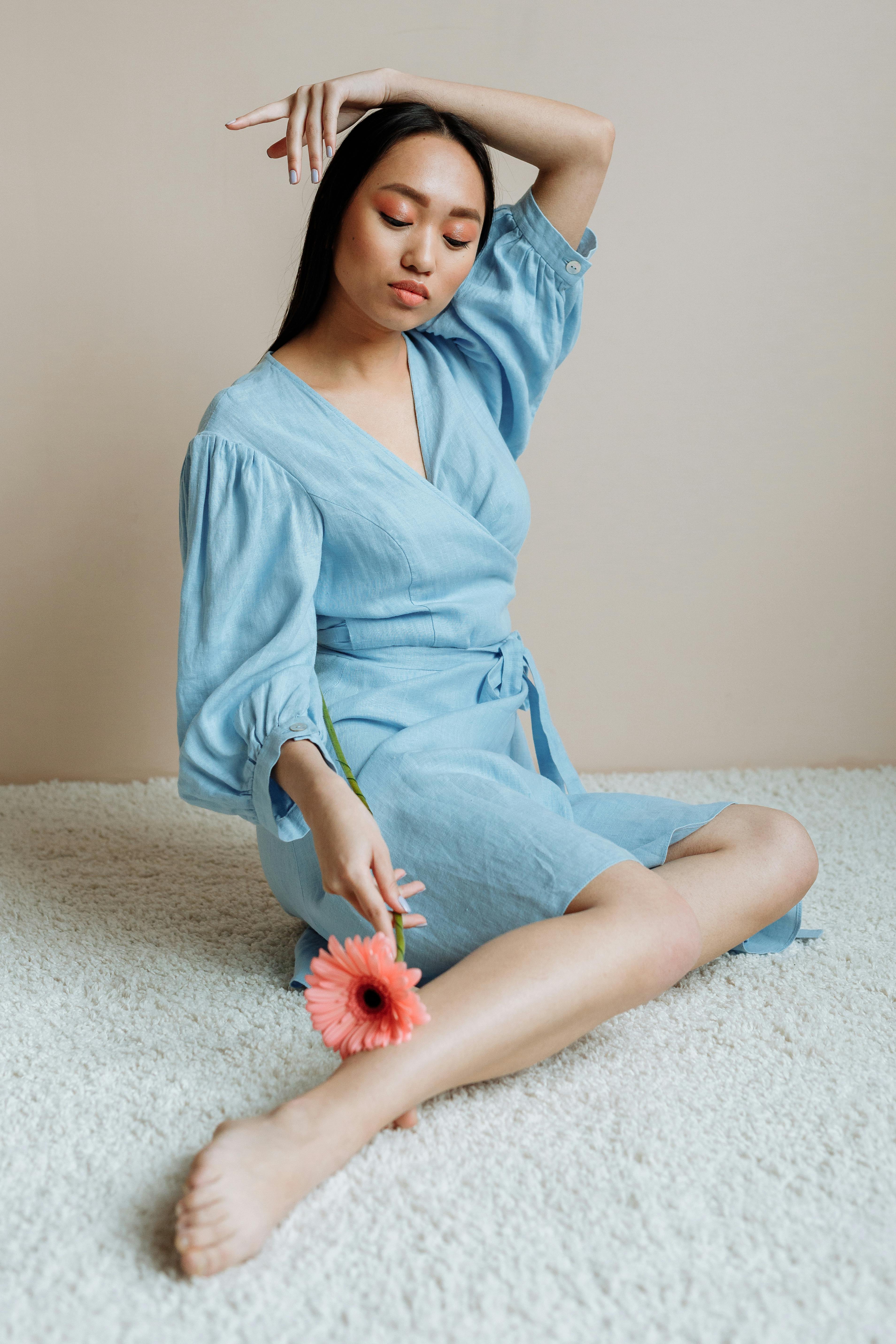 Woman Sitting on the Carpet holding Flower · Free Stock Photo