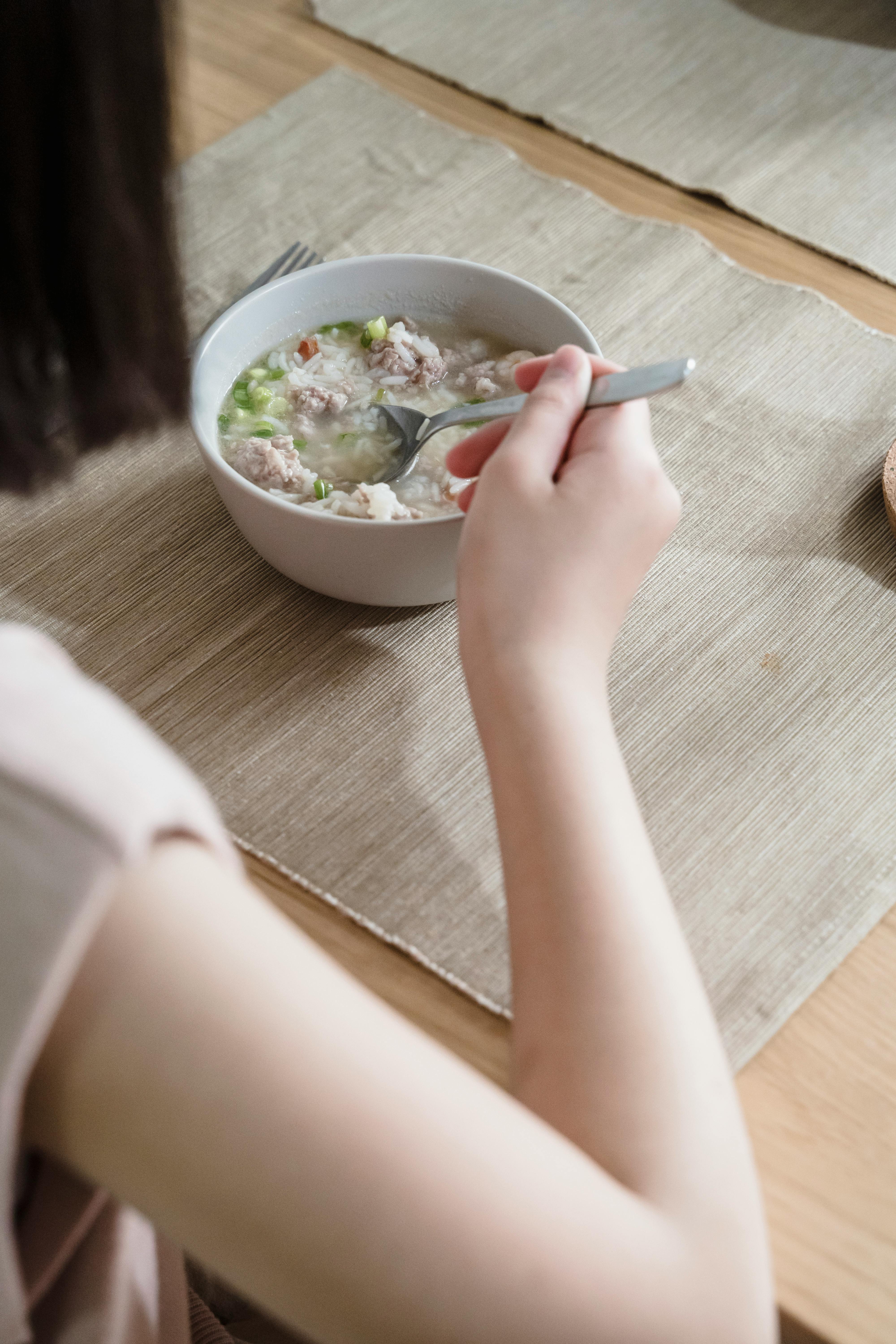 A Person Eating a Rice congee · Free Stock Photo