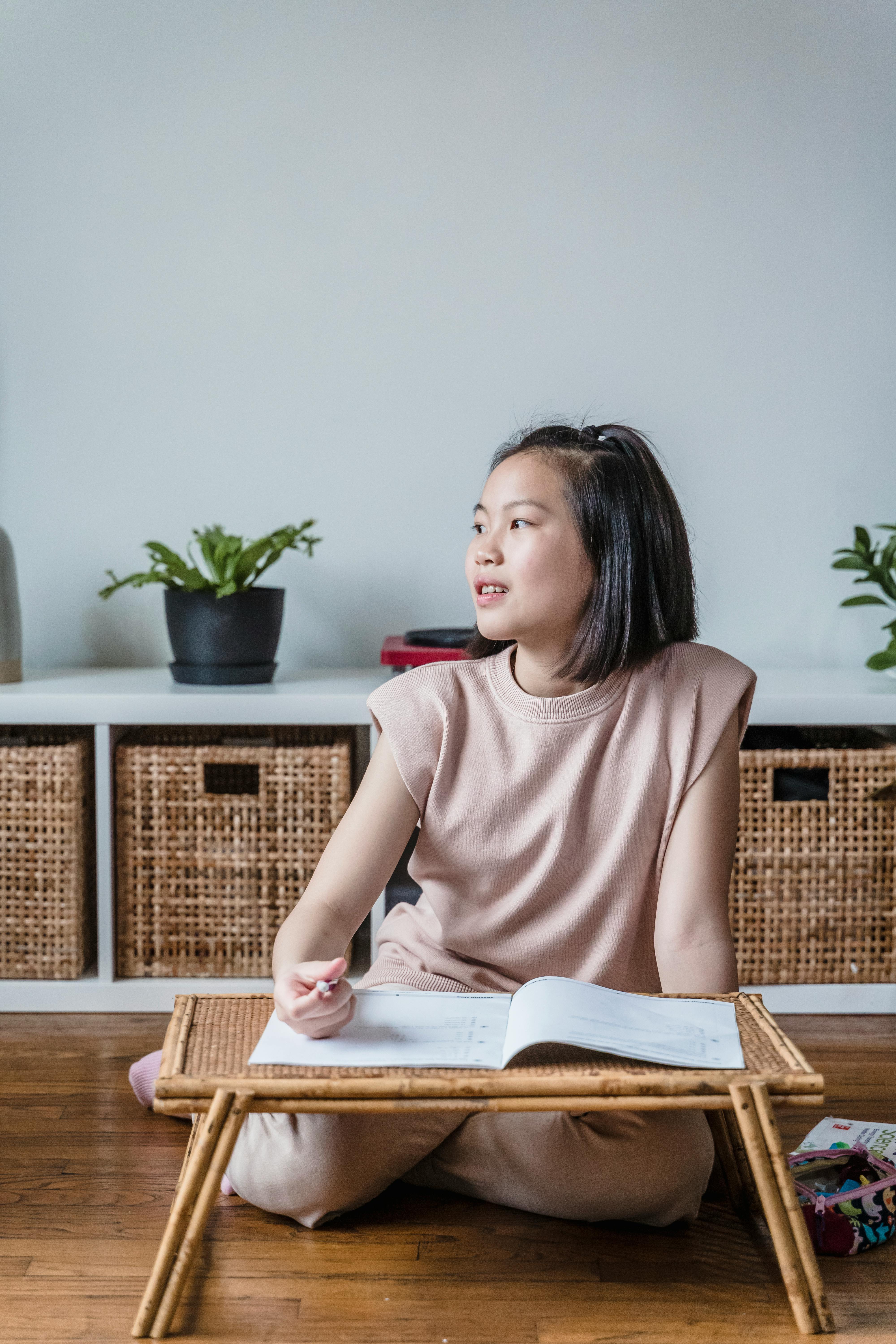 A Girl Doing her Homework on a Bed Tray · Free Stock Photo