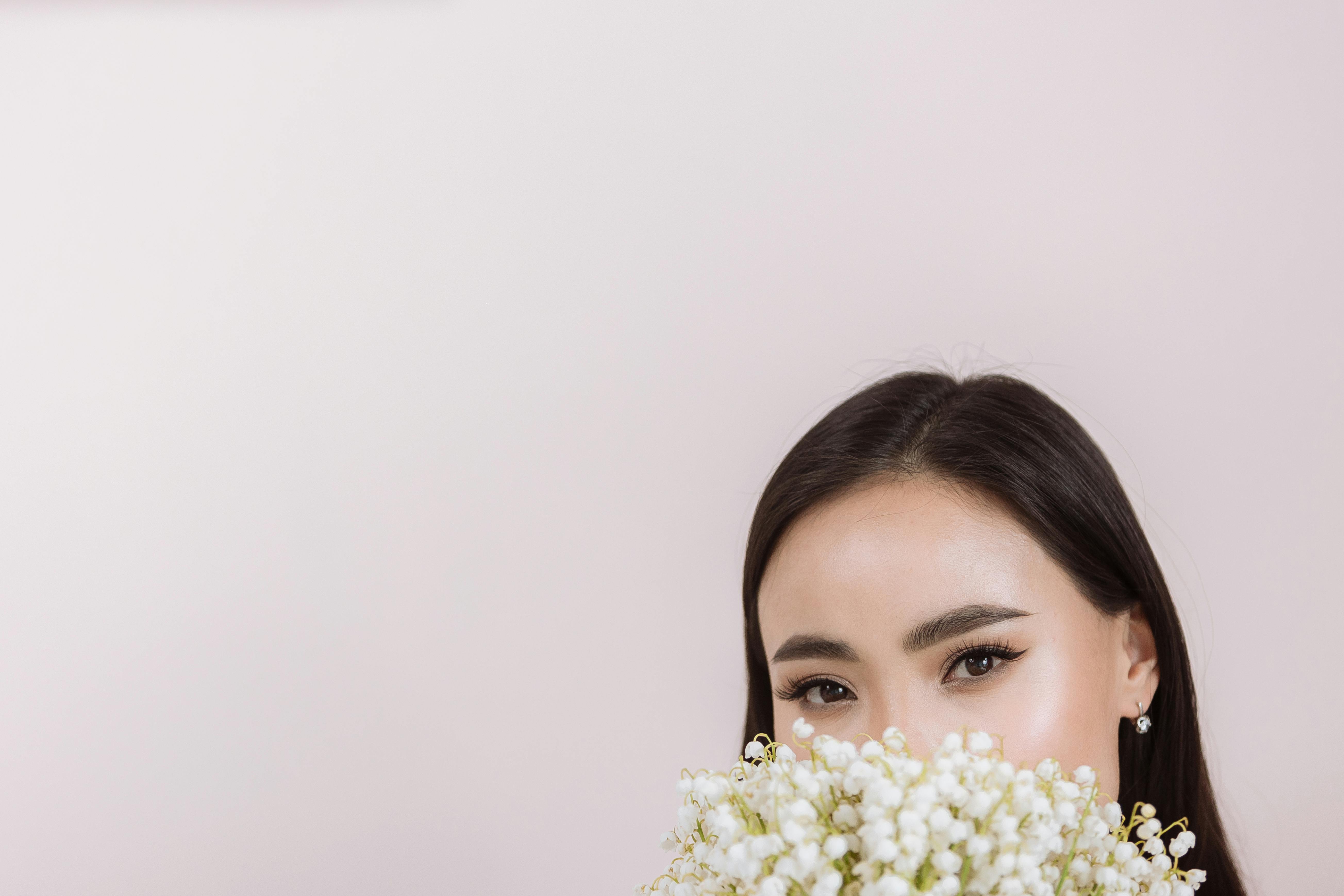 A Woman Covering Her Face with Flowers · Free Stock Photo